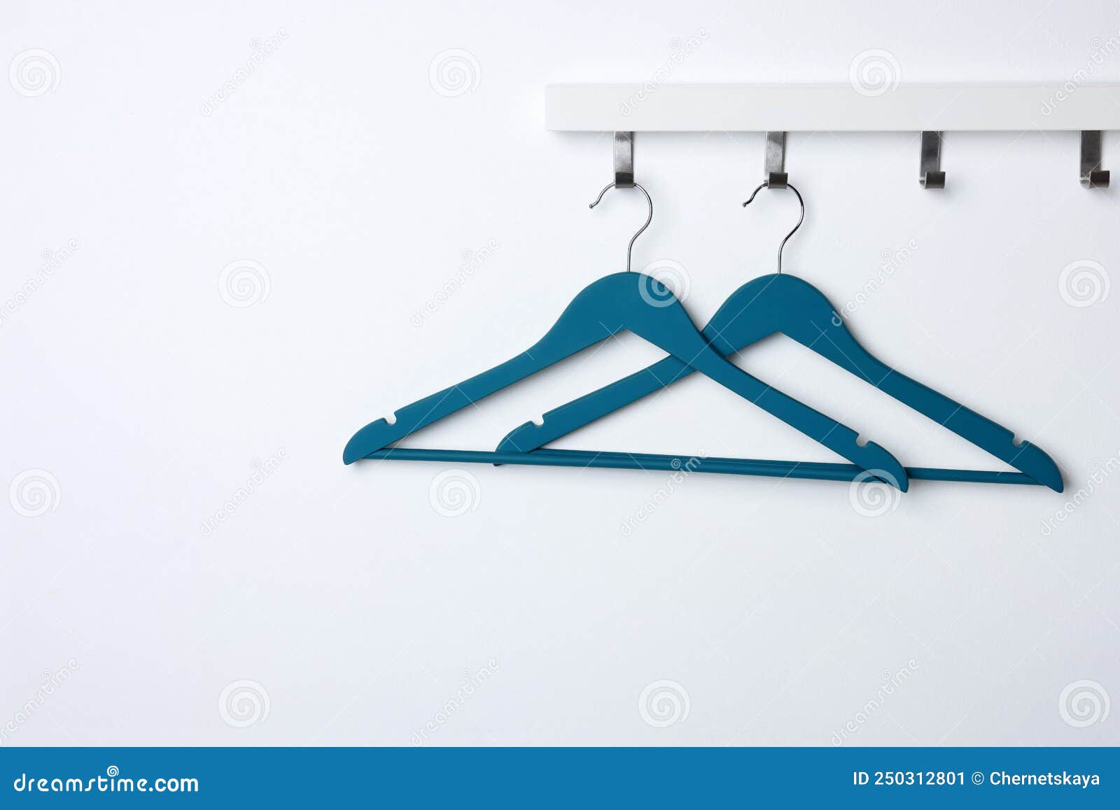 Rack with Empty Blue Clothes Hangers on White Wall Stock Image - Image ...