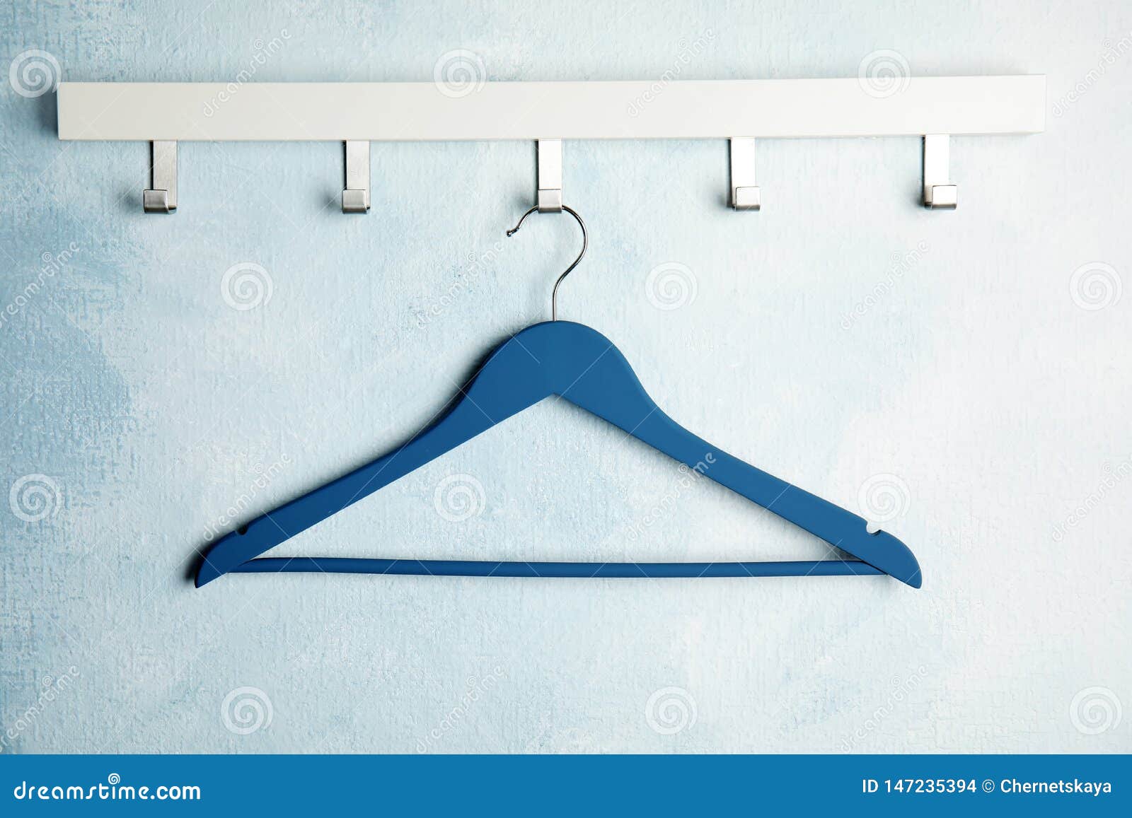 Rack with Empty Clothes Hanger on Color Wall. Stock Photo - Image of ...