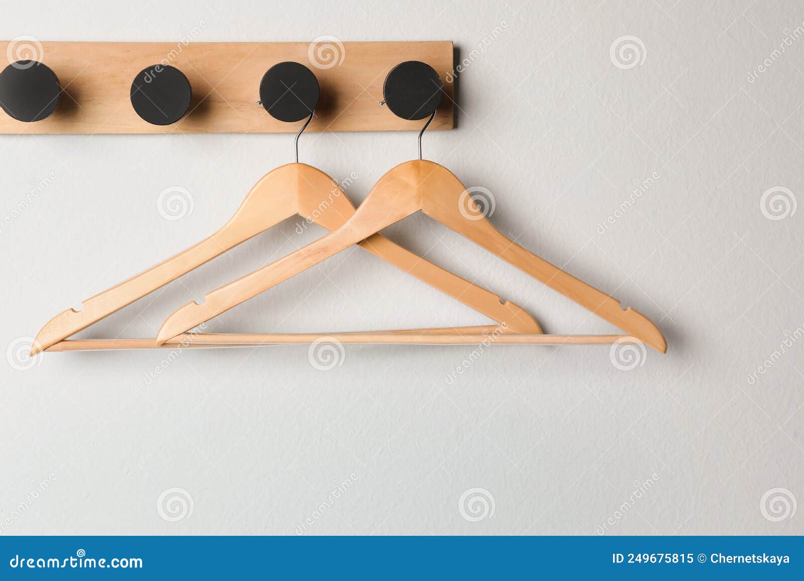 Rack with Empty Wooden Clothes Hangers on White Wall Stock Image ...