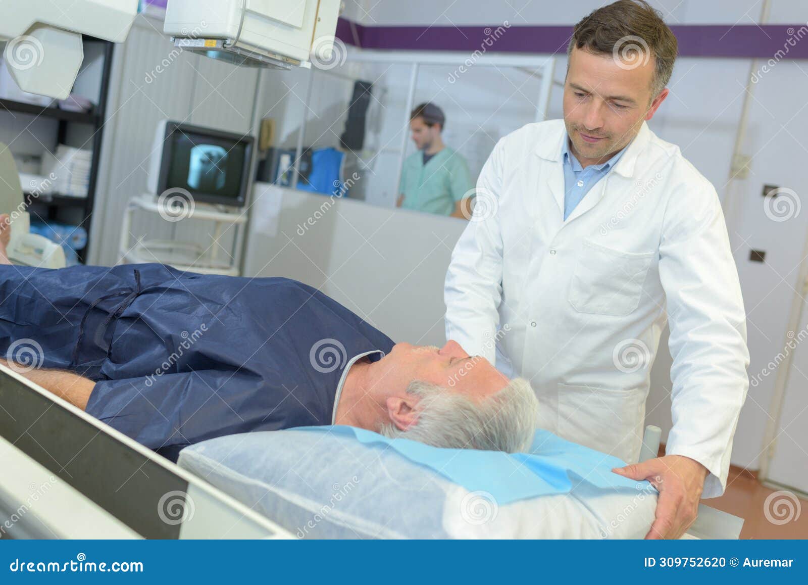 Radiologist Adjusting Xray Machine Over Man Stock Photo - Image of ...