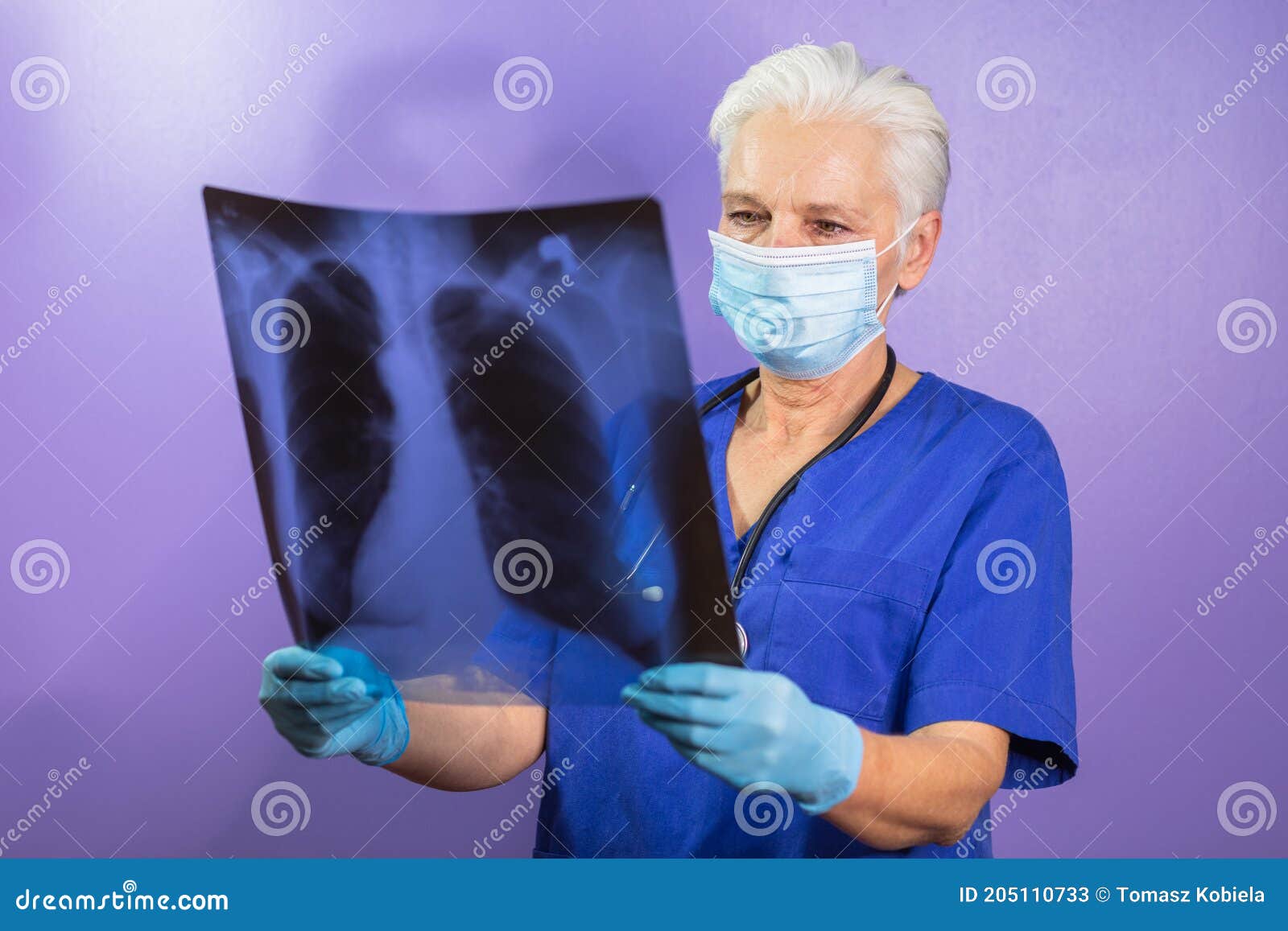 A Radiologist in Protective Clothing Examining a Chest X-ray Stock ...