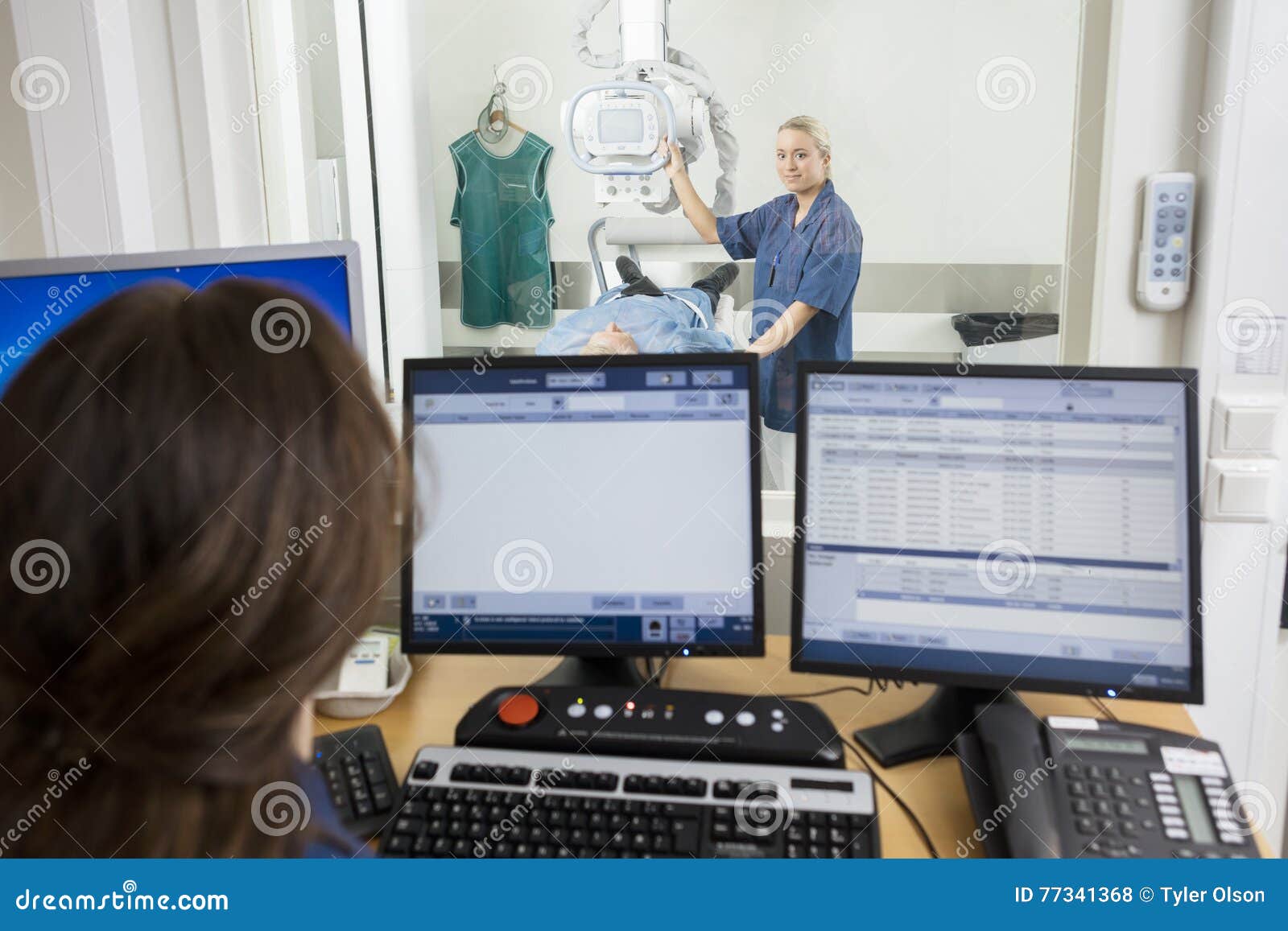 Radiologist Taking Patients Xray while Coworker Using Computers Stock ...