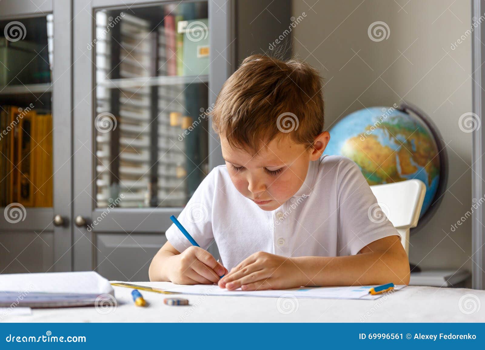 Ragazzo al suo compito immagine stock. Immagine di istruzione - 69996561