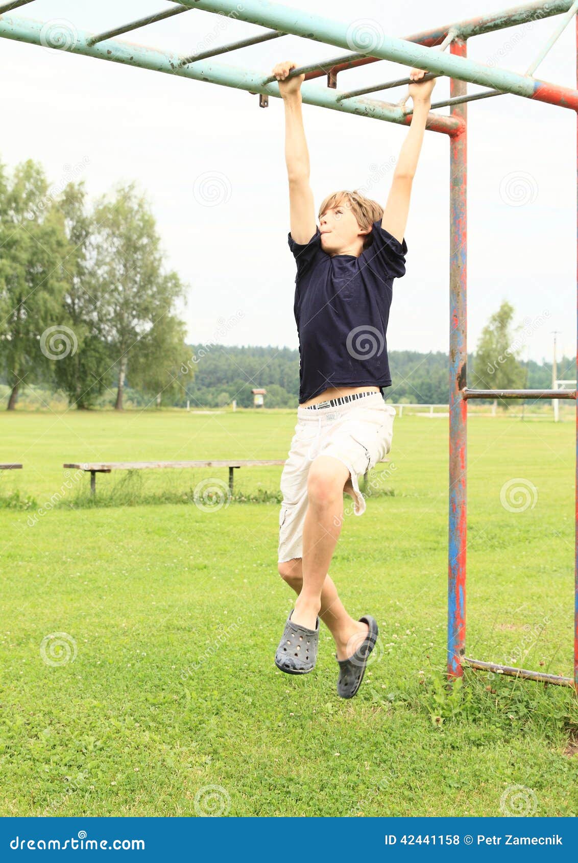 Ragazzo Che Appende Sulla Corsa Ad Ostacoli Fotografia Stock - Immagine ...