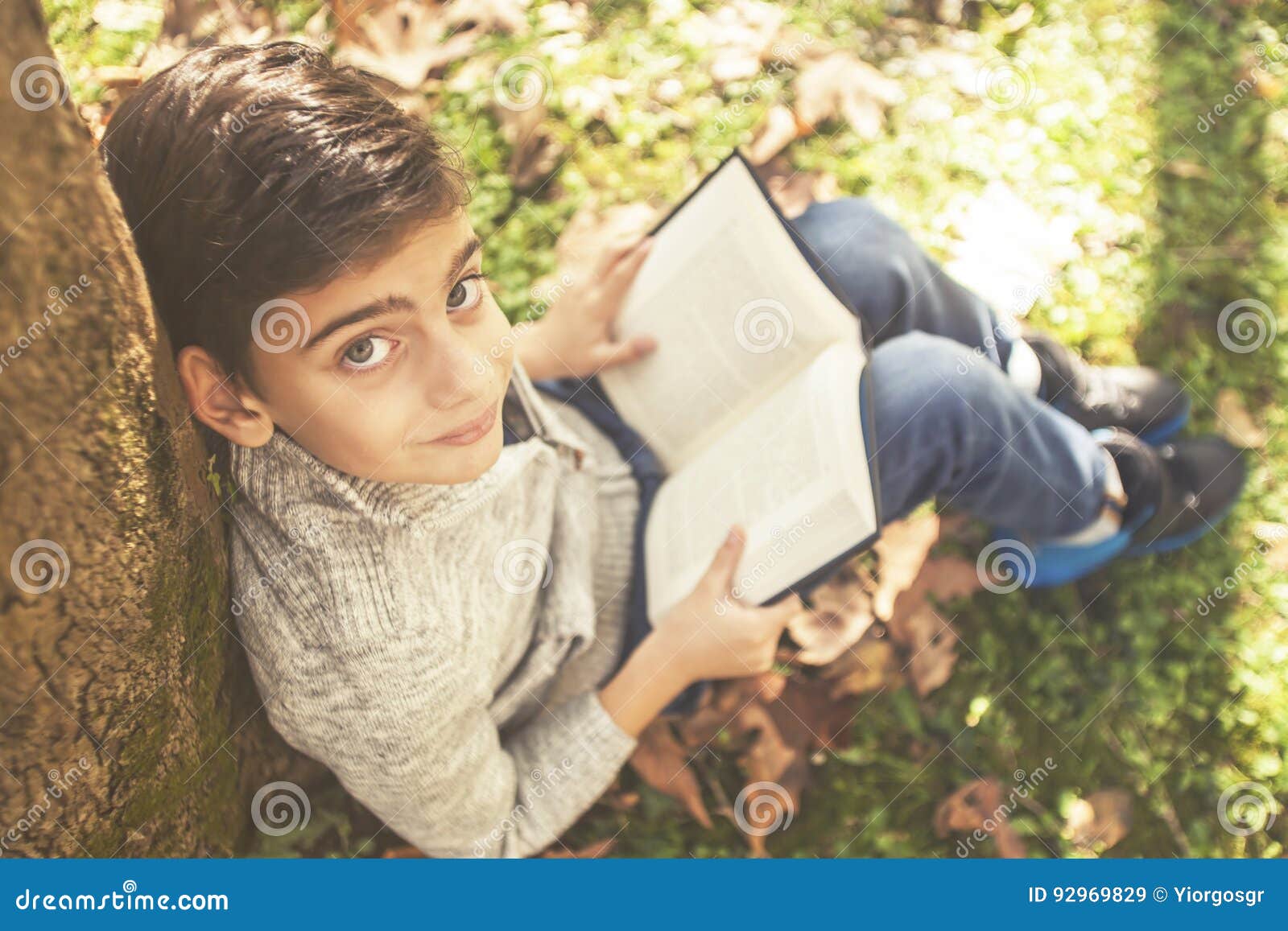 Ragazzo che legge un libro immagine stock. Immagine di casco - 92969829