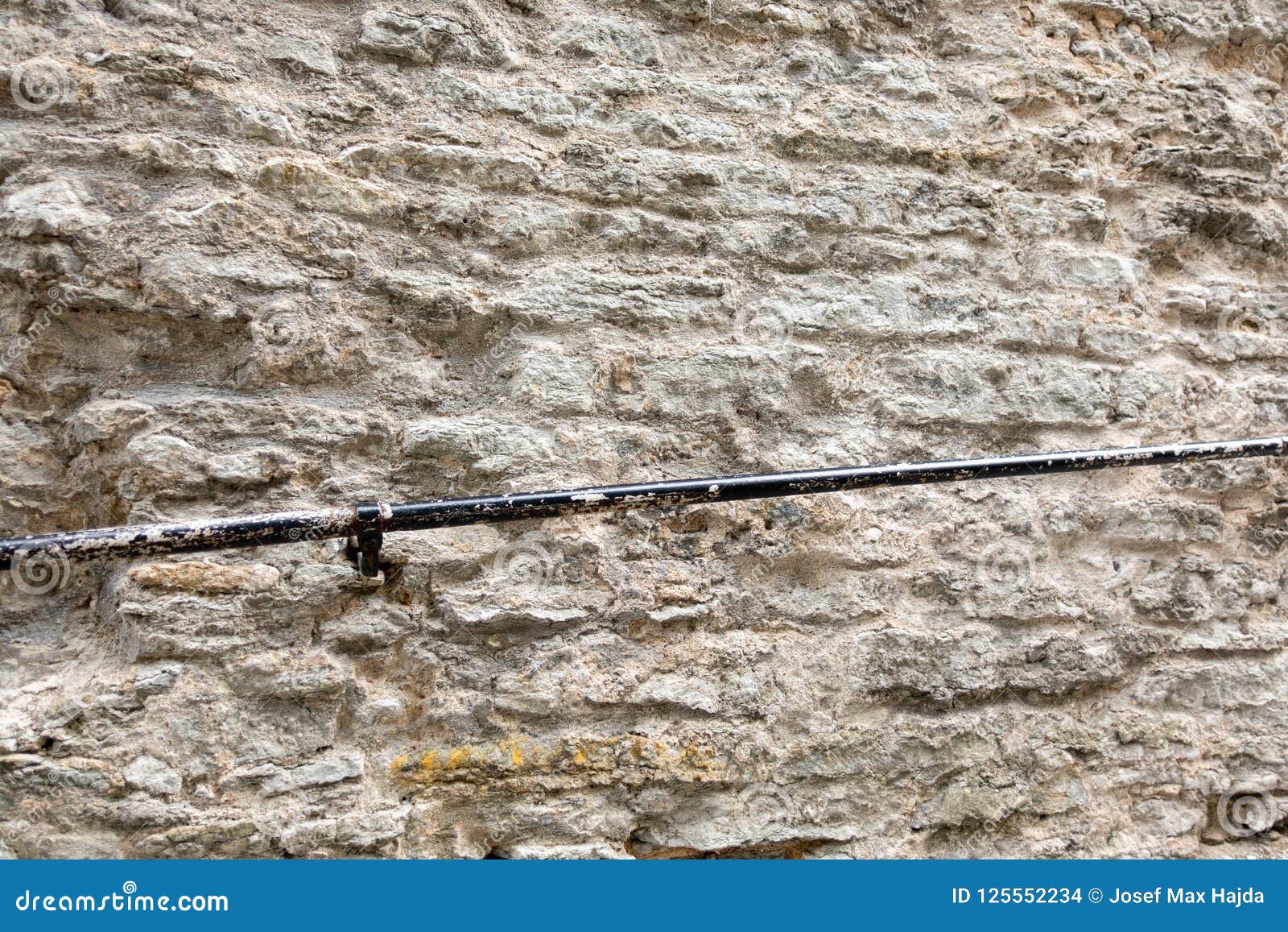 Rail on a wall of stones stock photo. Image of texture - 125552234