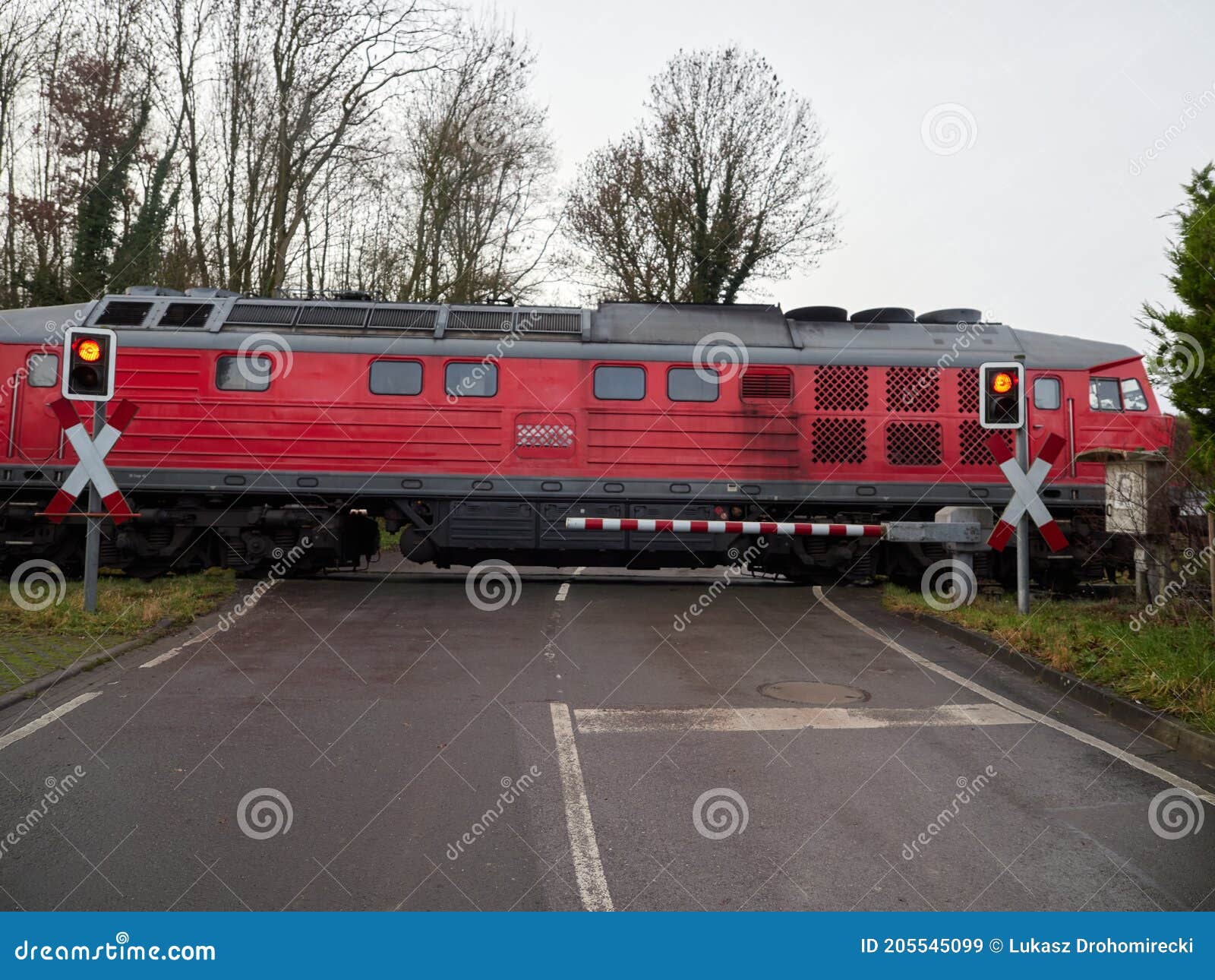 Railroad Crossing with a Closed Barrier and a Passing Train. Stock ...