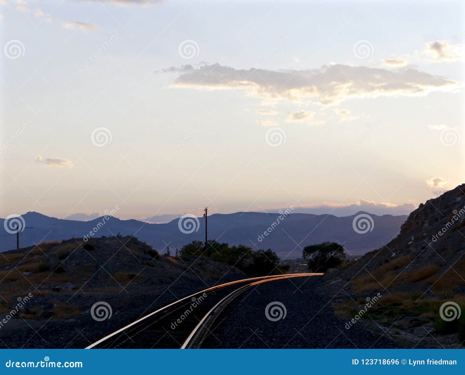 Railroad Tracks Curving Around Bend, Illuminated by Sunset, Mountain ...