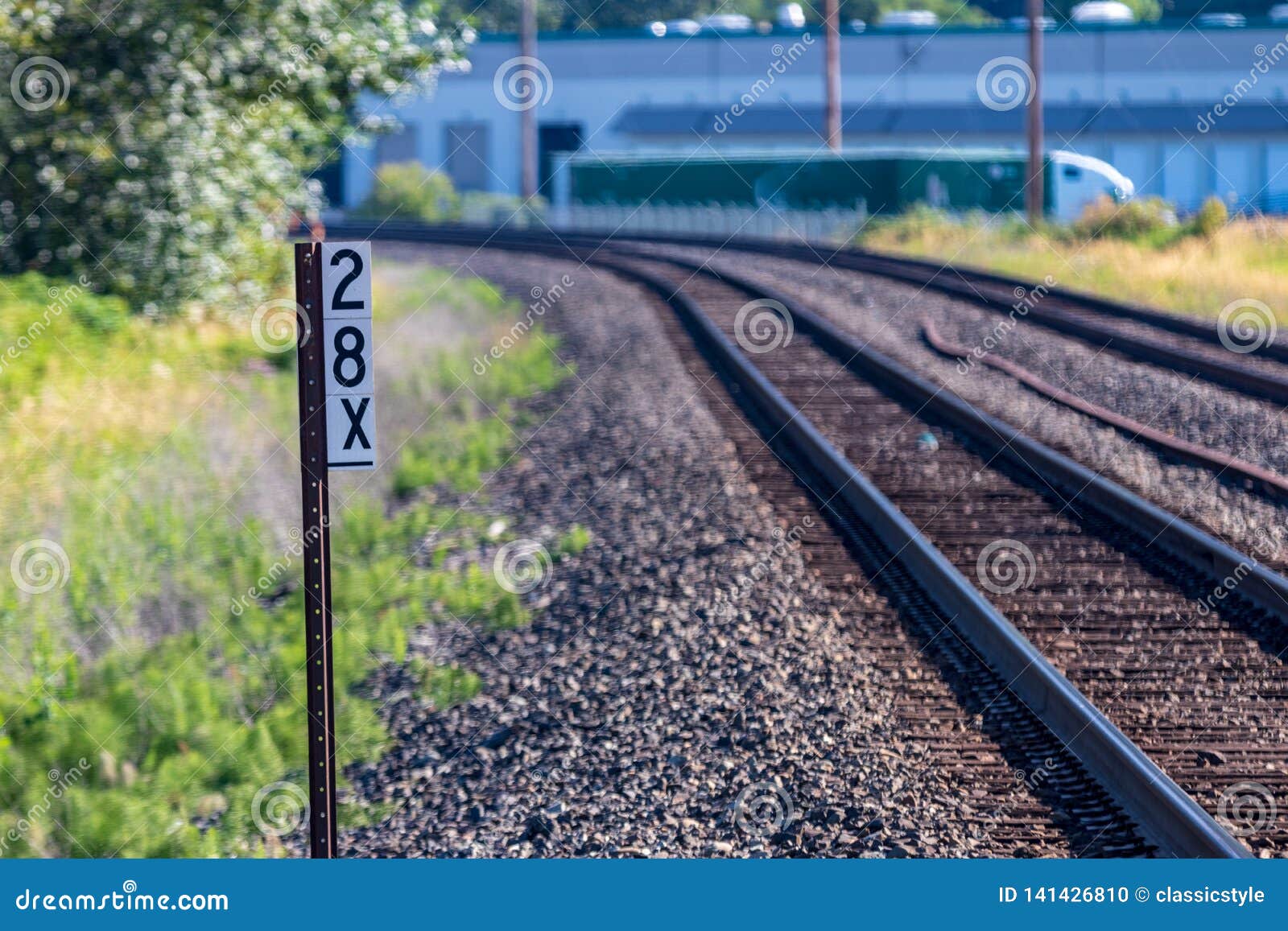 Railroad Tracks and Sign with Building in the Distance Stock Photo ...