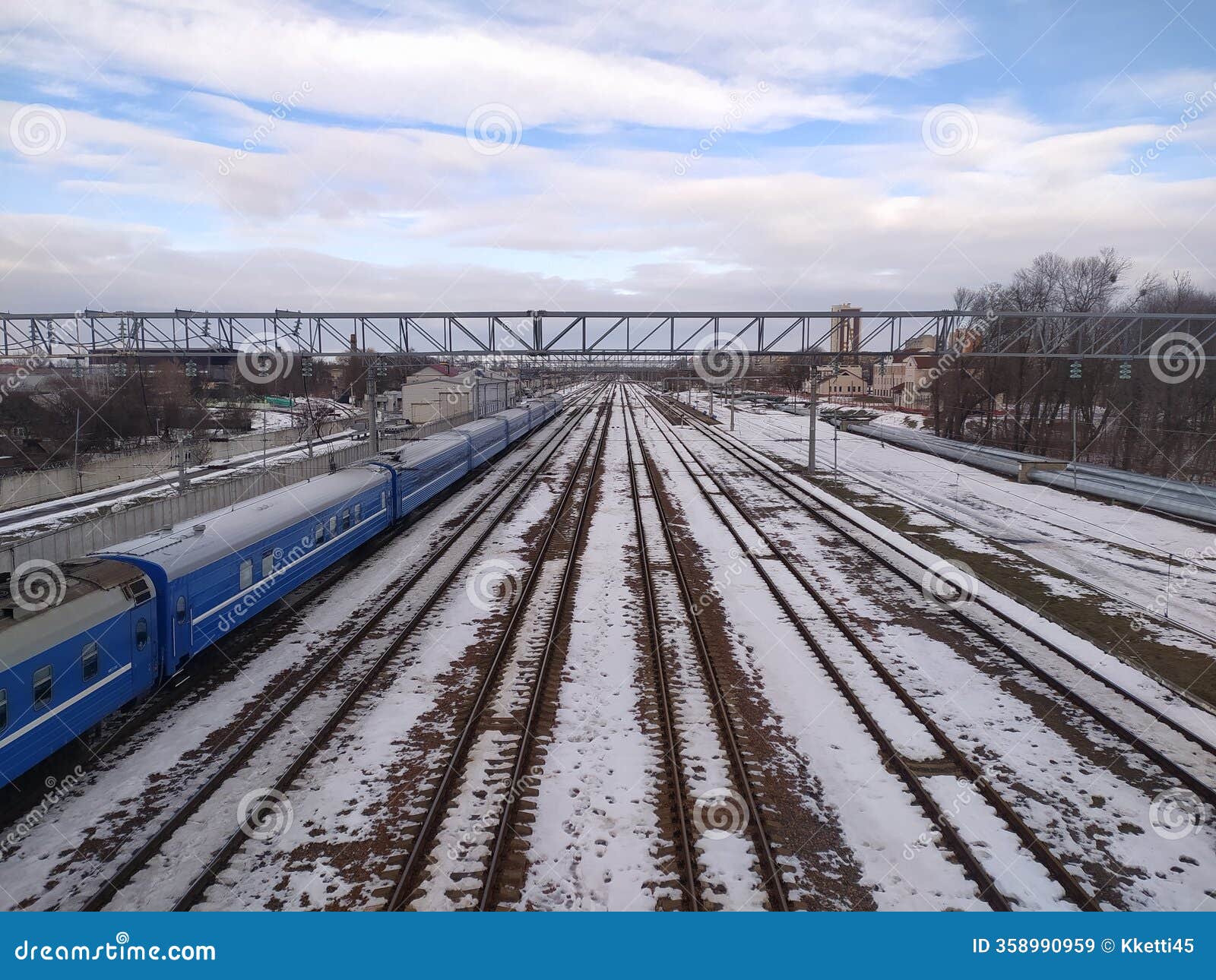 Railroad Tracks in Winter with Snow and Blue Train in Background Stock ...