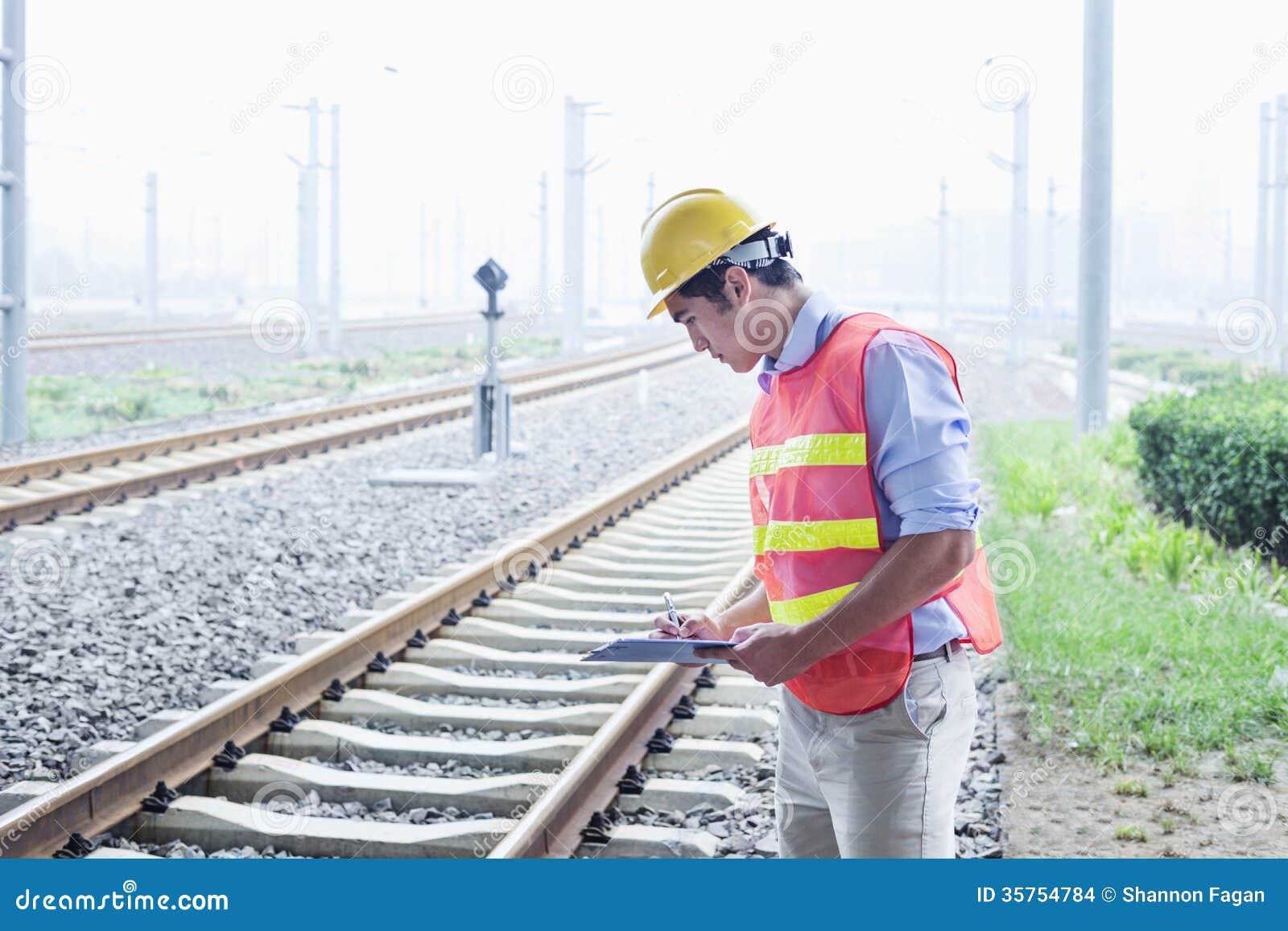 Railroad Worker in Protective Work Wear Checking the Railroad Tracks ...