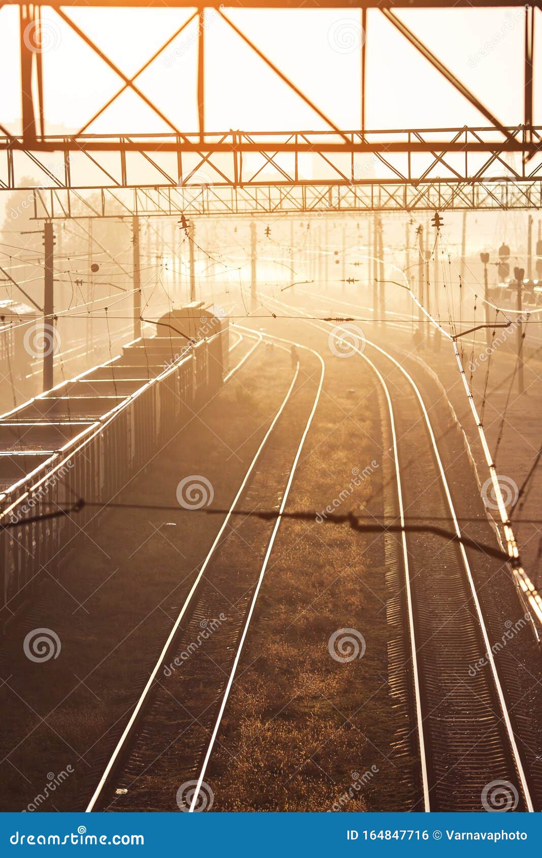Railway with Freight Train at Sunset with Sun Stock Photo - Image of ...