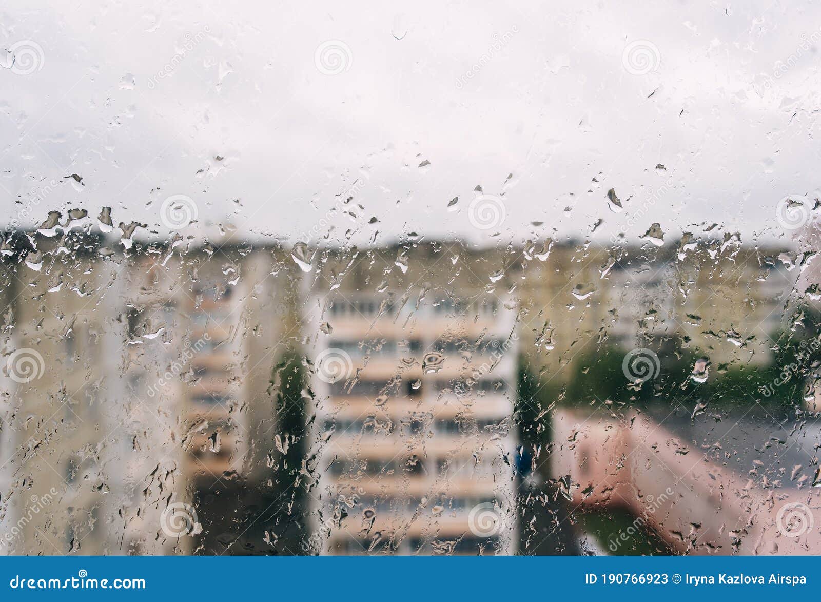 Rain Falls on the Surface of the Window Pane Against the Background of ...