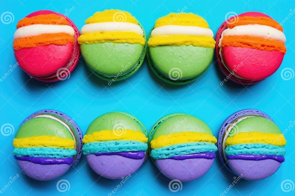 Rainbow-colored Macarons Arranged Vertically on a Bright Blue Surface ...
