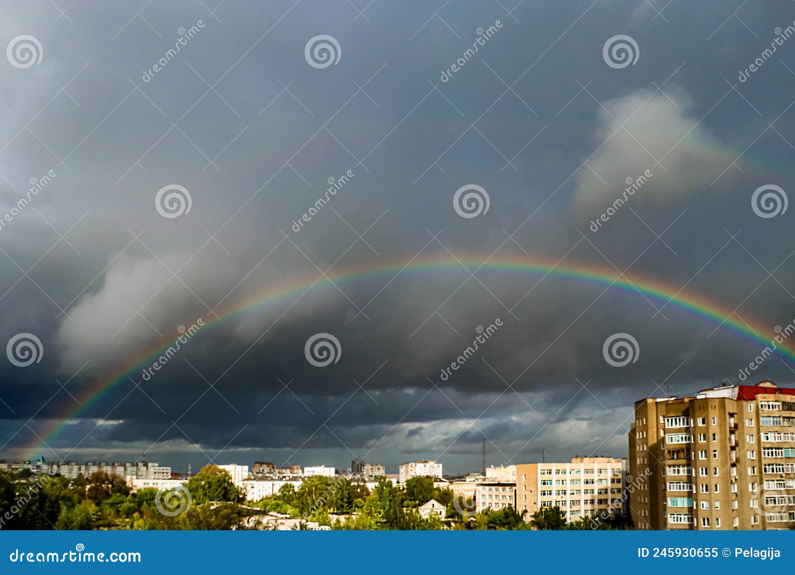 Rainbow Over City. Atmospheric Phenomenon in Sky Against Background of ...