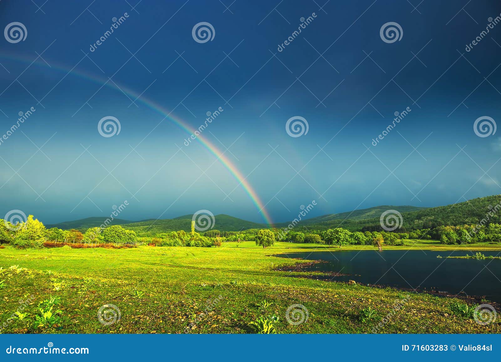 Rainbow over a lake stock image. Image of grass, scenery - 71603283
