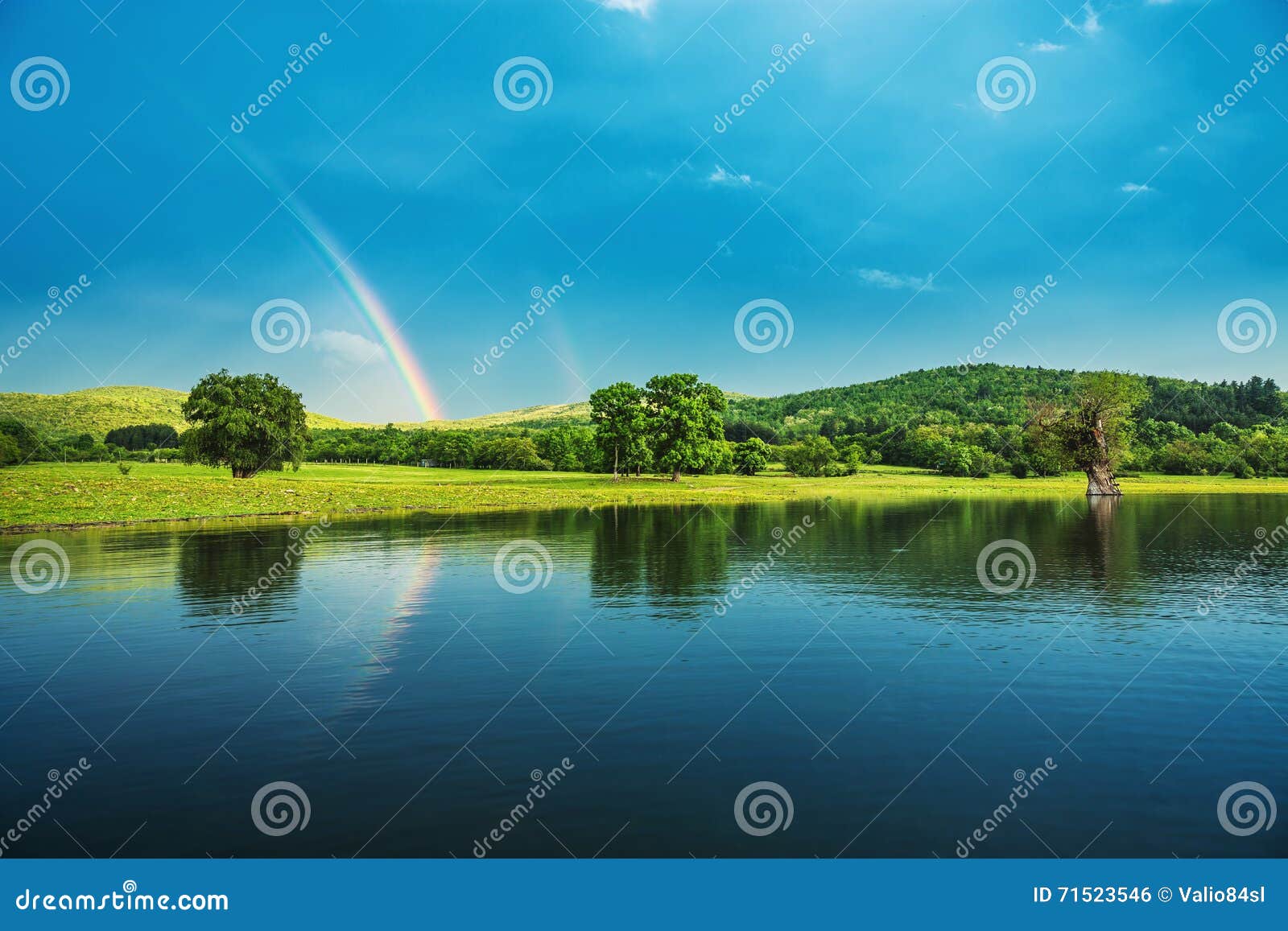 Rainbow Over a Lake, Reflected in the Water Stock Photo - Image of rain ...