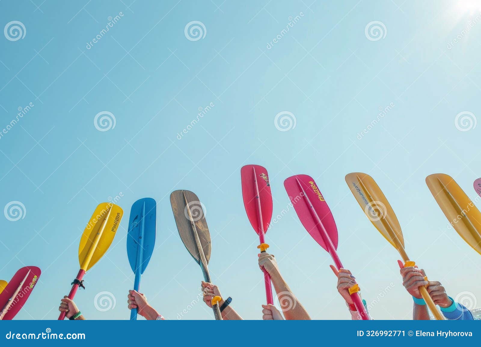 Raised Paddles Held by People Against a Clear Blue Sky, Representing ...