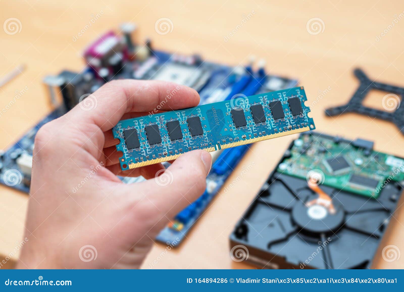 RAM Memory Module in Hand. Motherboard and Hard Disk in Background ...