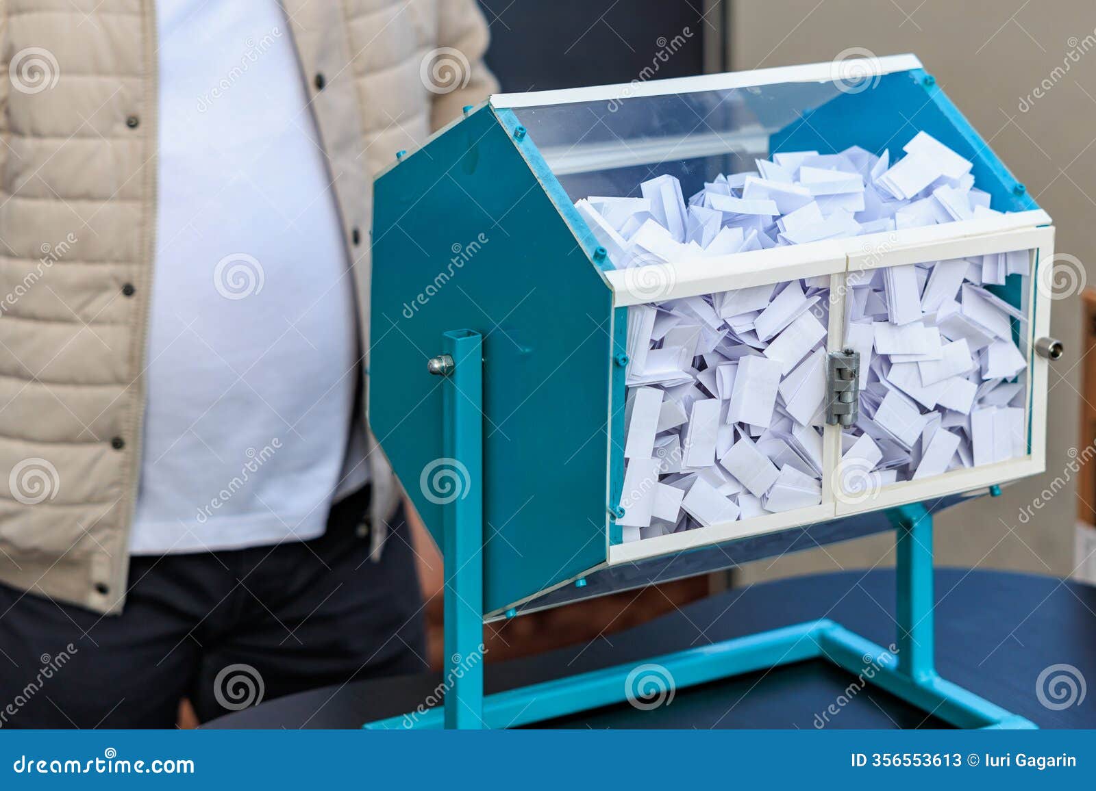 Random Drawing Lottery Drum with White Paper Slips in a Blue Box Stock ...