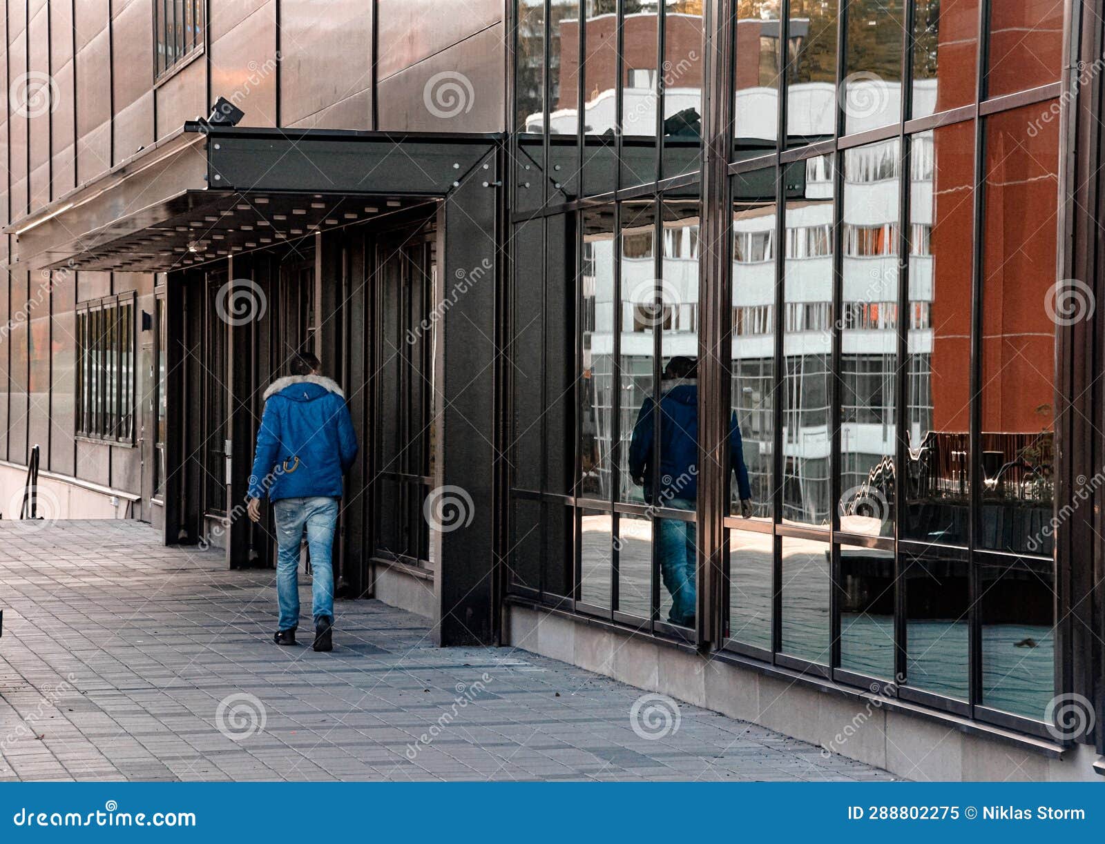 Rare View of a Man Walking in Front of a Building Stock Image - Image ...