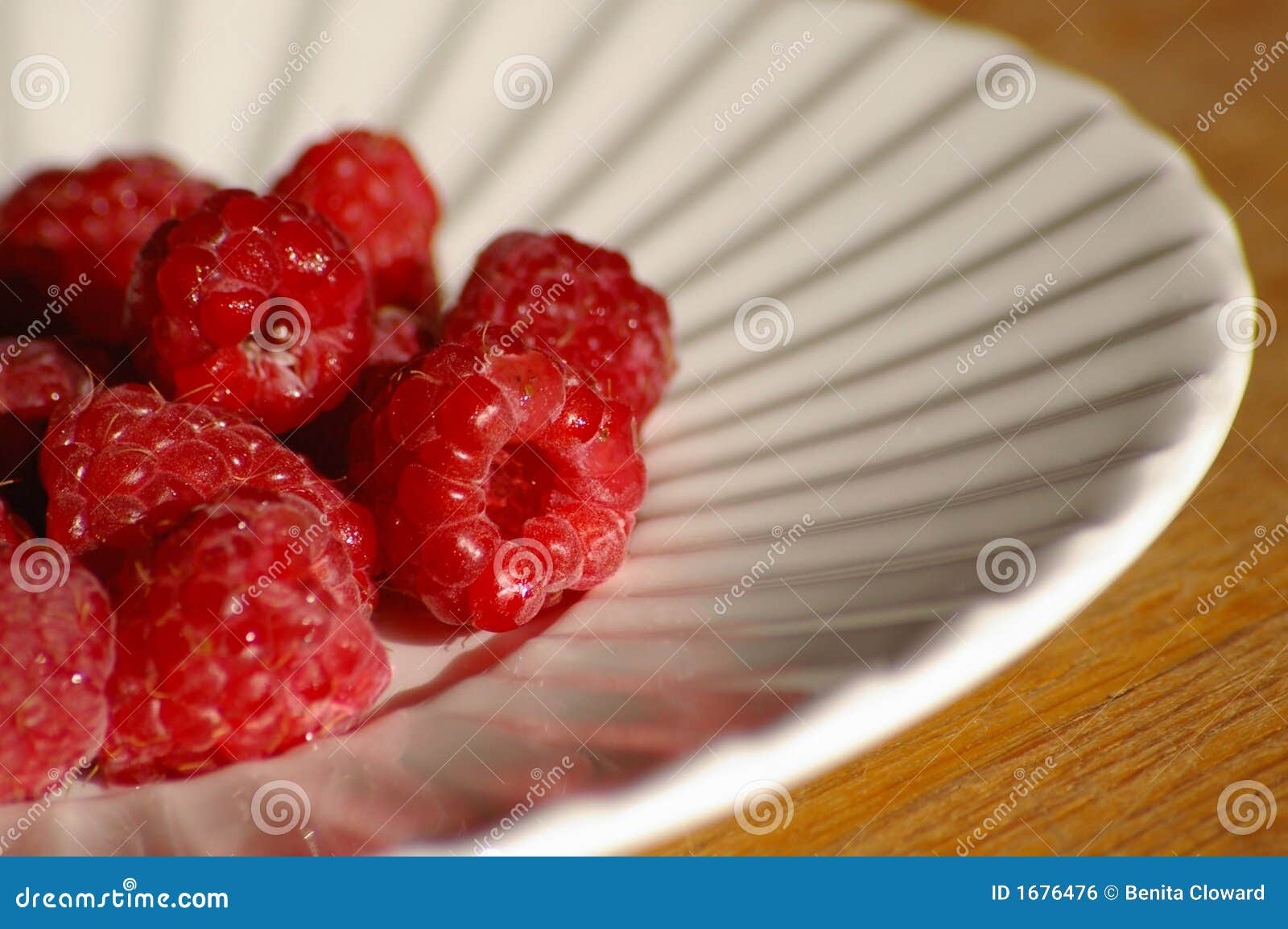 Raspberries on white plate stock photo. Image of fresh - 1676476