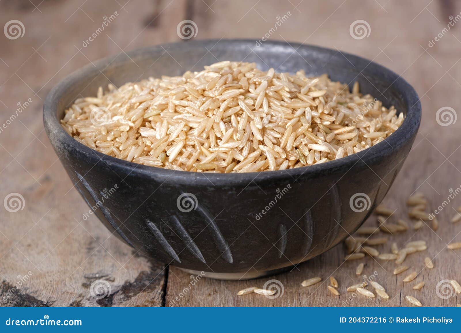 Raw brown rice in a bowl stock photo. Image of cereal - 204372216