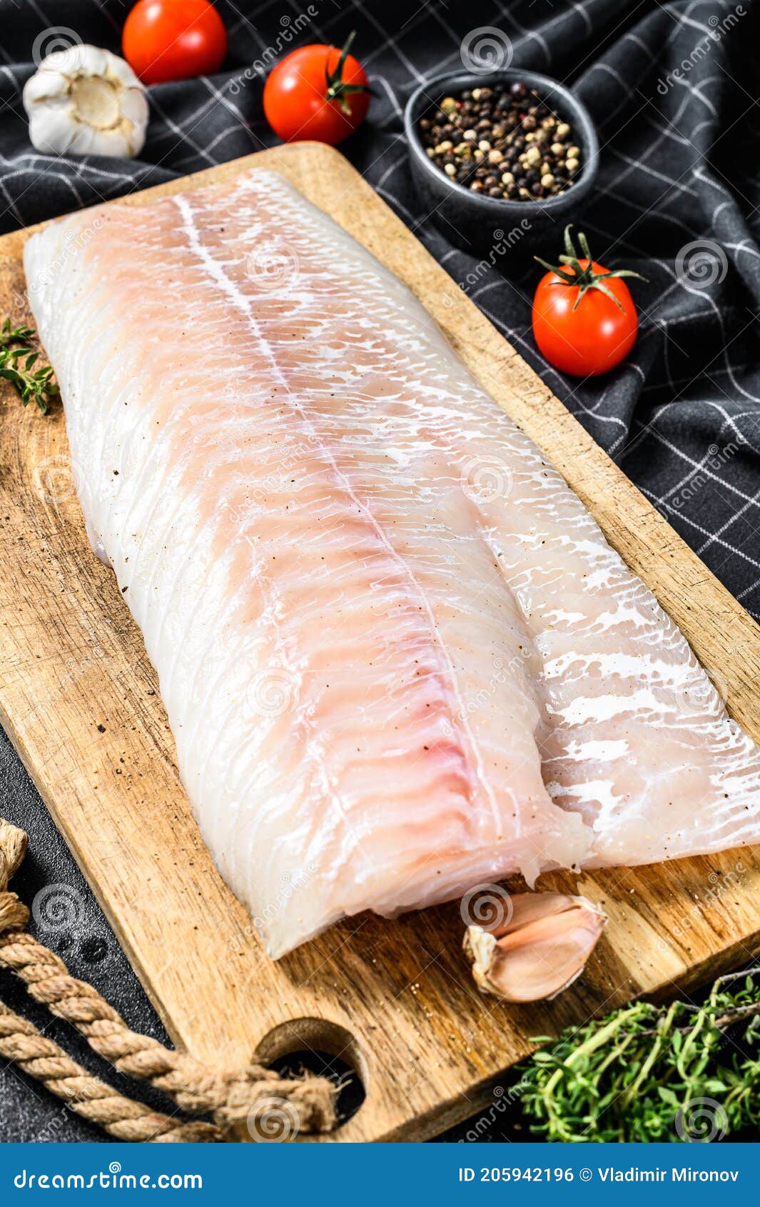 Raw Cod Fillet with and Herbs on Rustic Wooden Cutting Board. Black ...