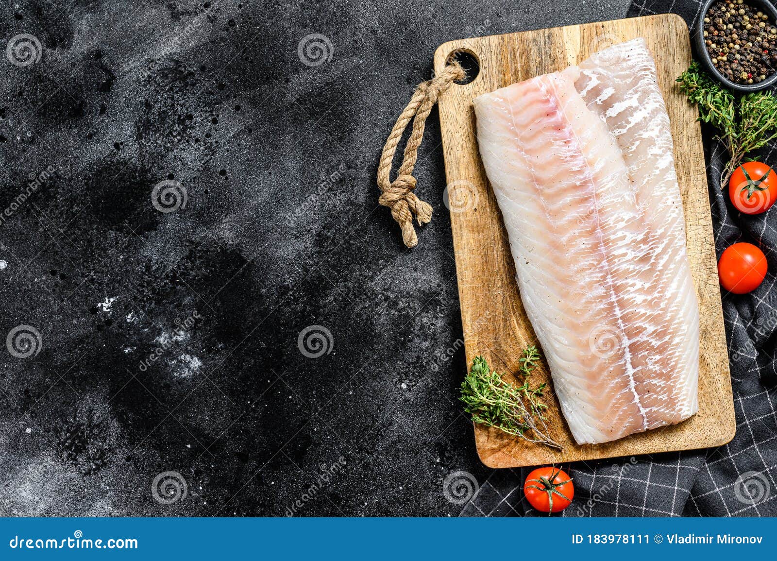 Raw Cod Fillet with and Herbs on Rustic Wooden Cutting Board. Black ...