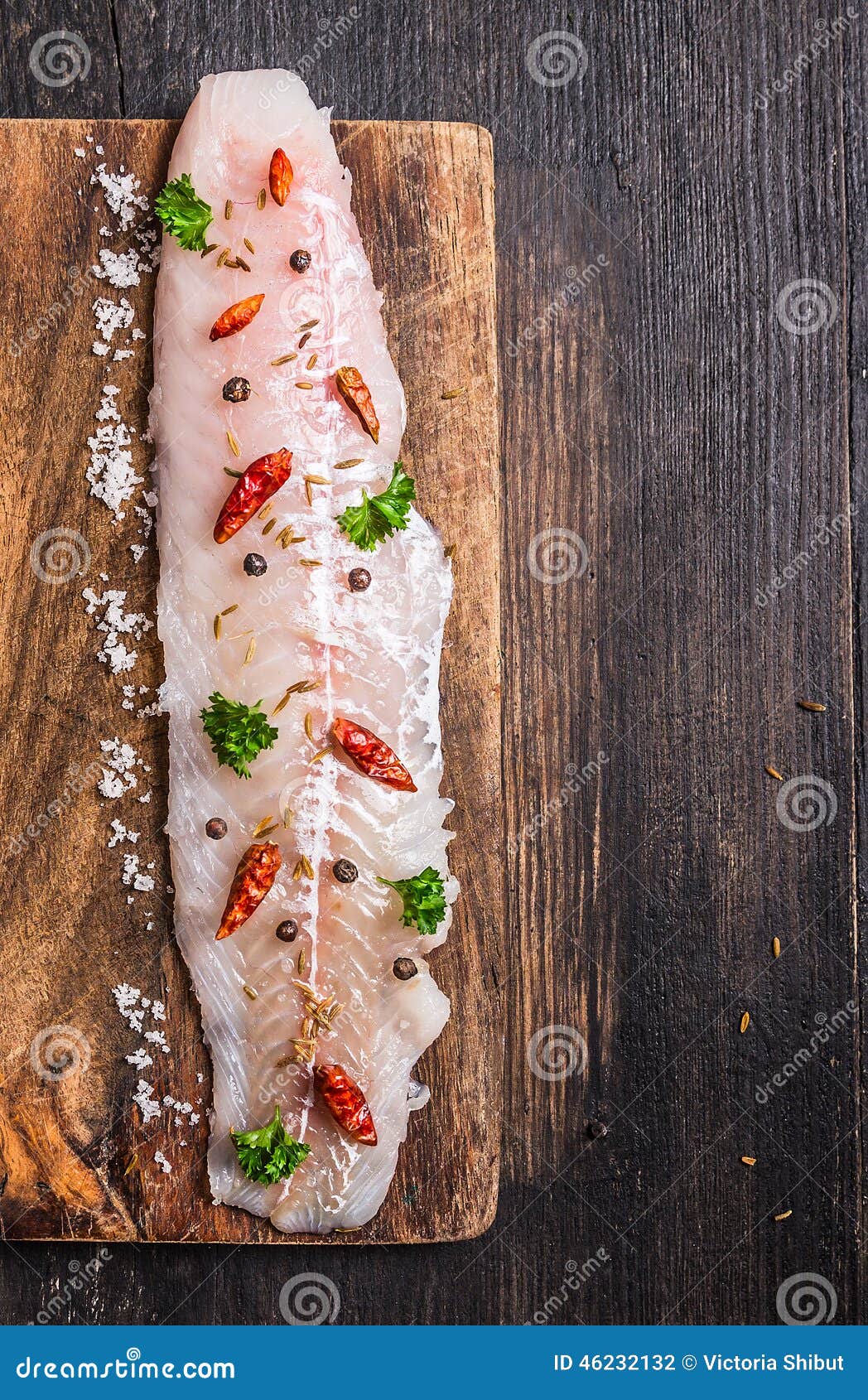 Raw Fish Fillet with Herbs and Spices on Dark Cutting Board Stock Photo ...