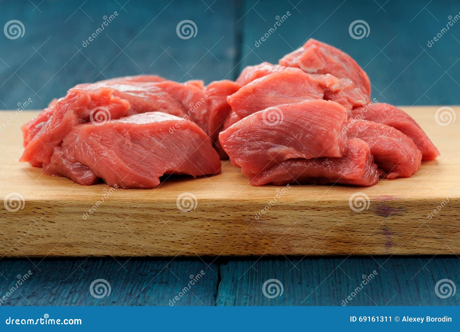 Raw Lean Meat Cuts on Wooden Board on Deep Blue Background Stock Image ...