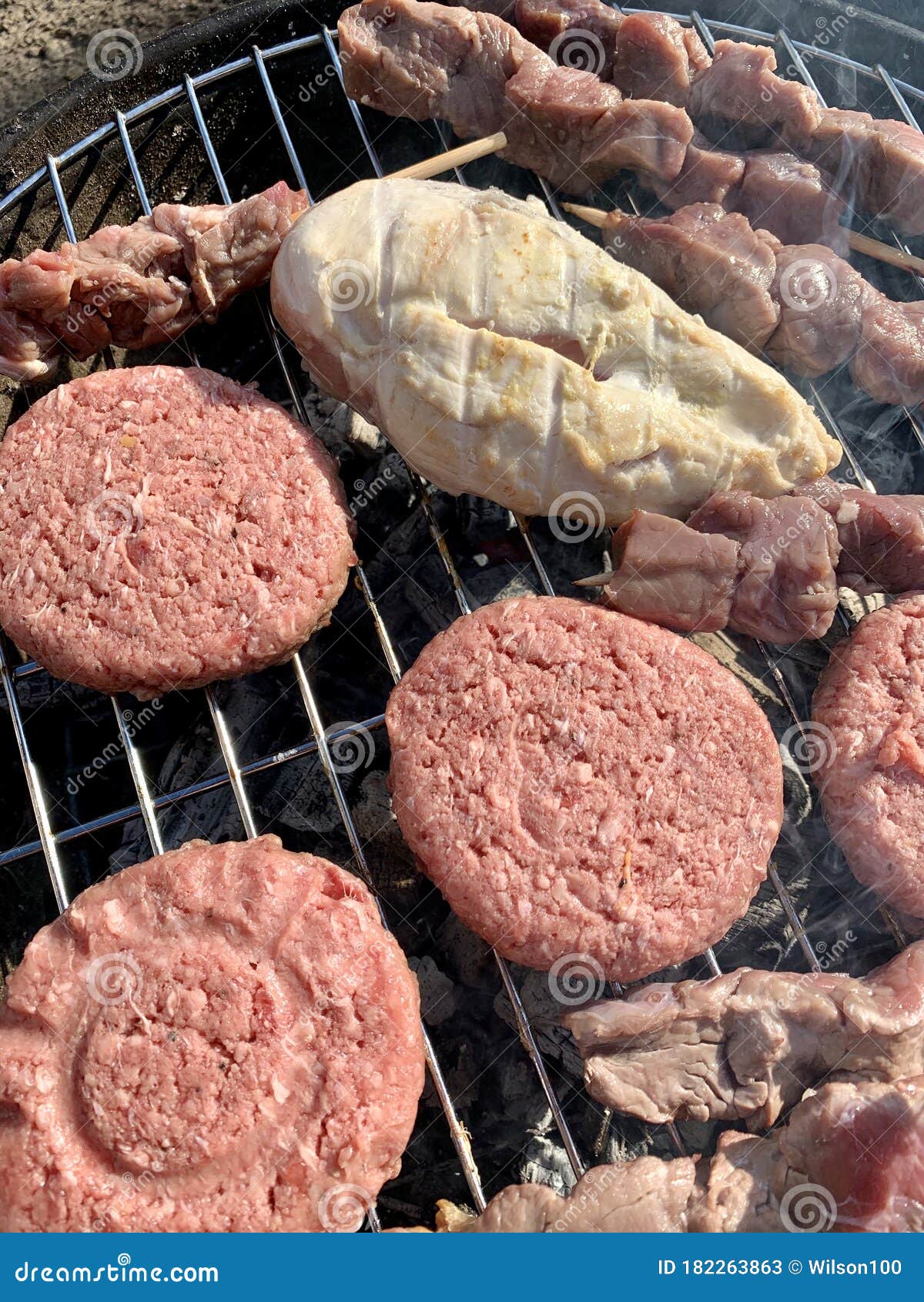 Raw meat cooking on a bbq stock image. Image of burger - 182263863