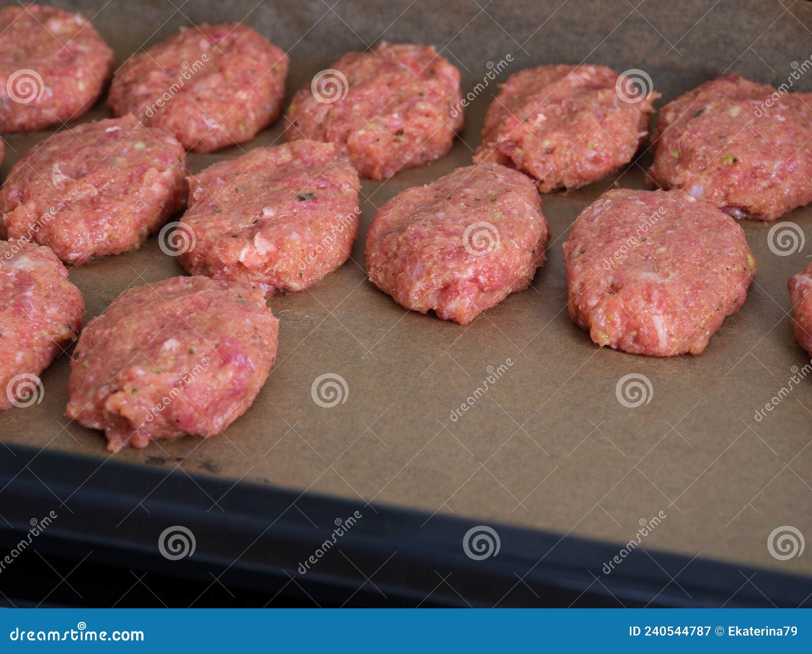 Raw Meat Cutlets on Parchment Paper in a Baking Sheet Stock Image ...