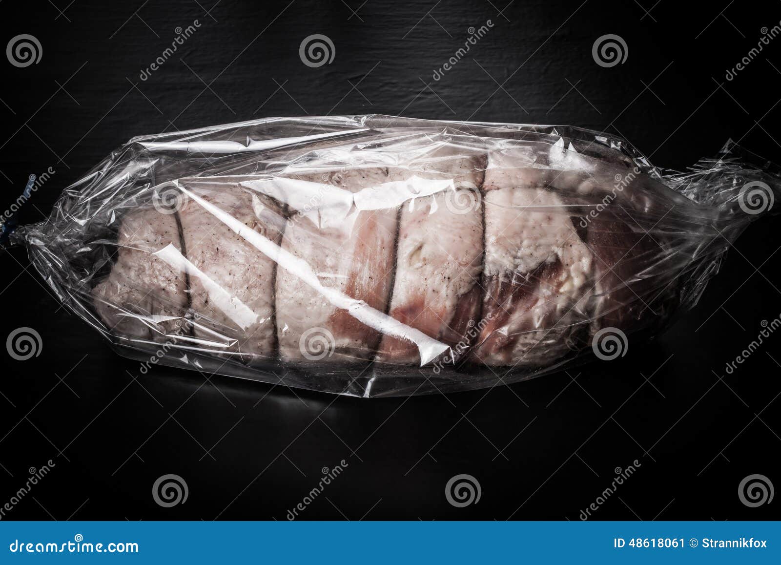 Raw Meat with Rope in the Package on a Black Background. Toned Stock ...