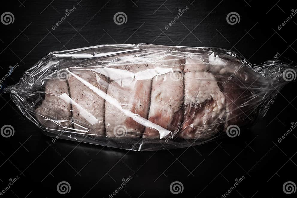 Raw Meat with Rope in the Package on a Black Background. Toned Stock ...