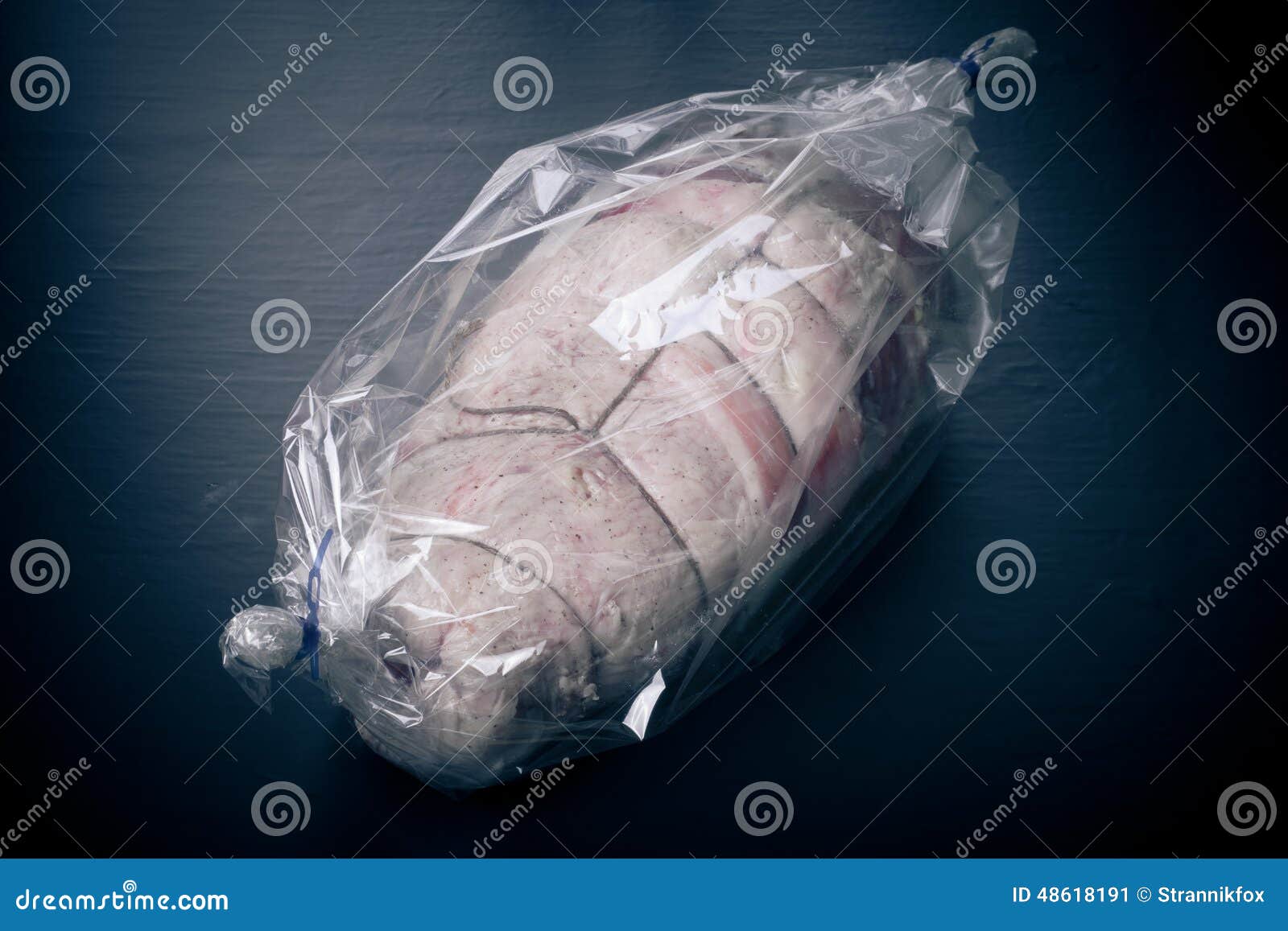 Raw Meat with Rope in the Package on a Black Background. Toned Stock ...