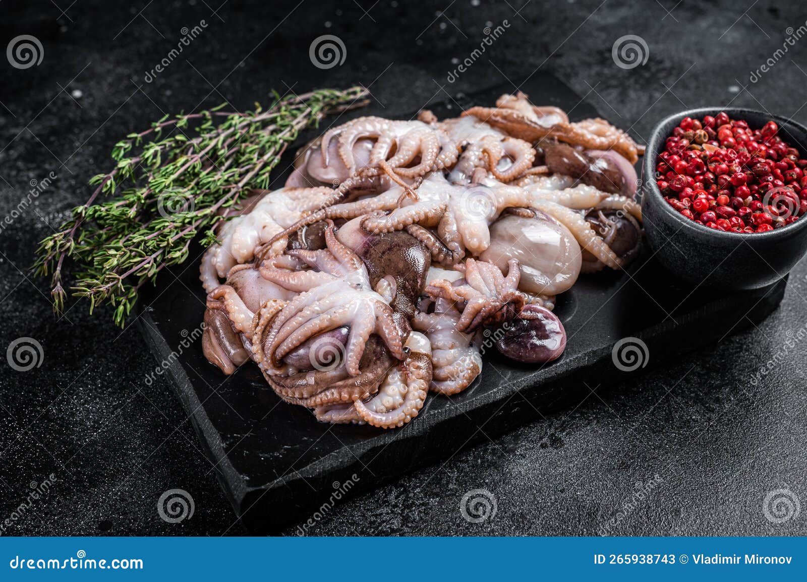 Raw Mini Baby Octopus on a Marble Board with Thyme. Black Background ...