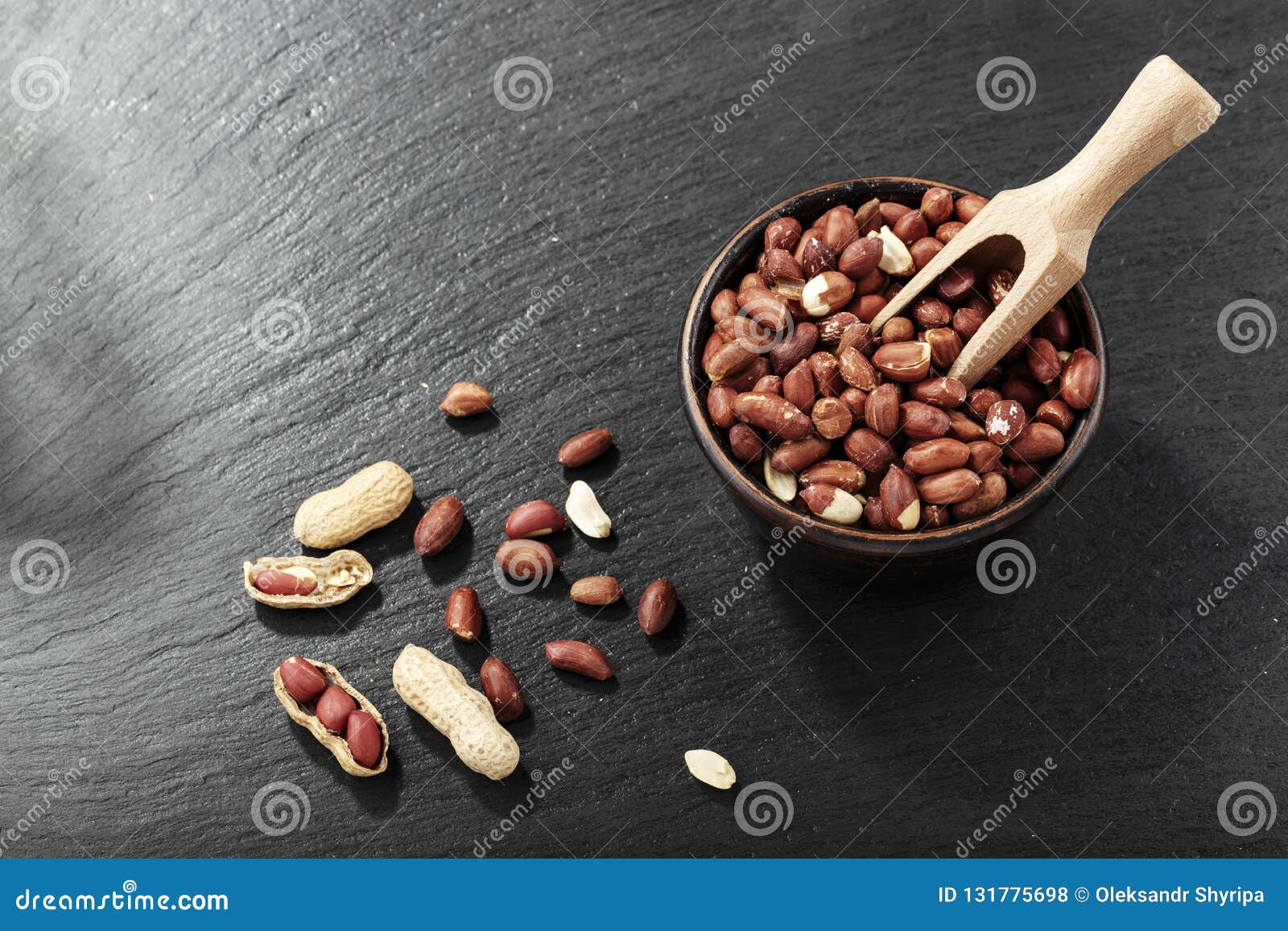 Raw Peeled Peanuts in a Plate and Scattered on a Black Background ...
