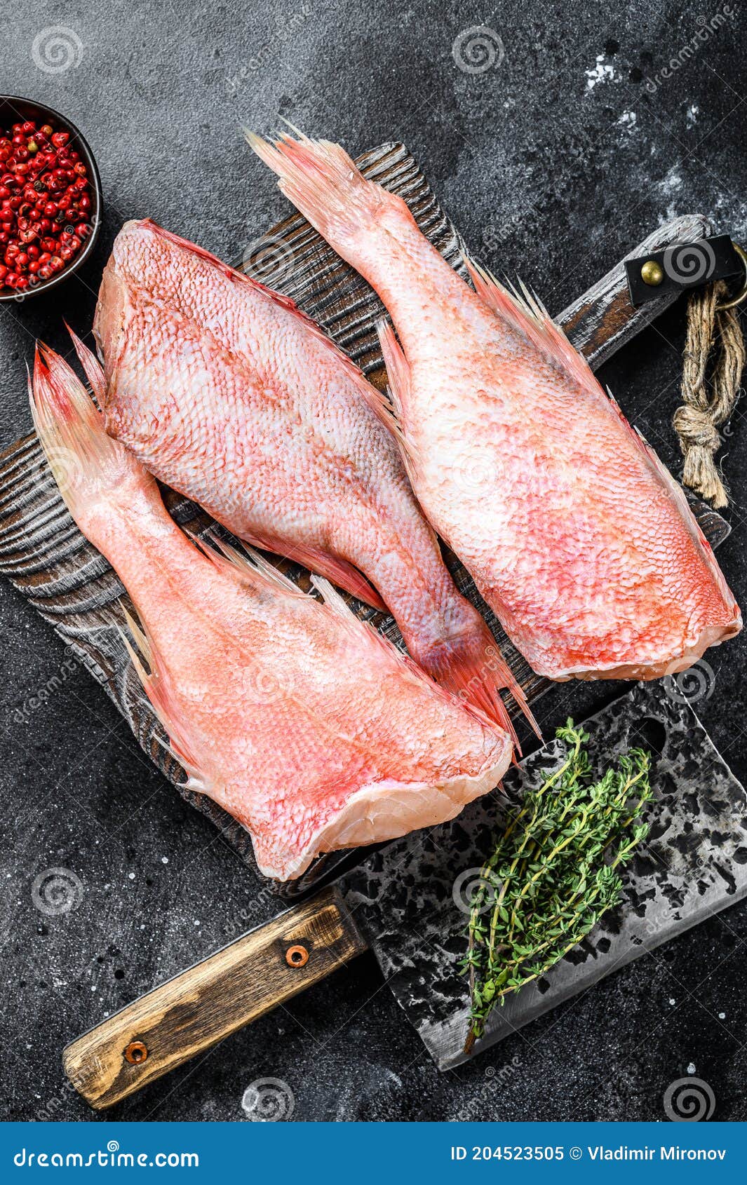 Raw Red Perch or Seabass Fish on a Cutting Board. Black Background ...