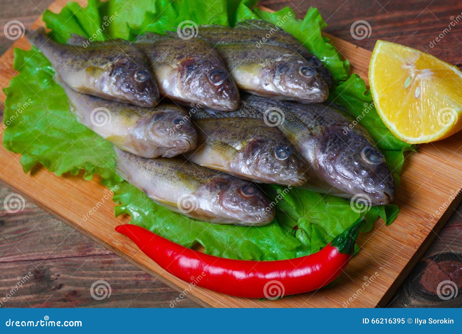 Raw Redfish Ruff Fish on the Kitchen Table with Vegetables and Lemon ...