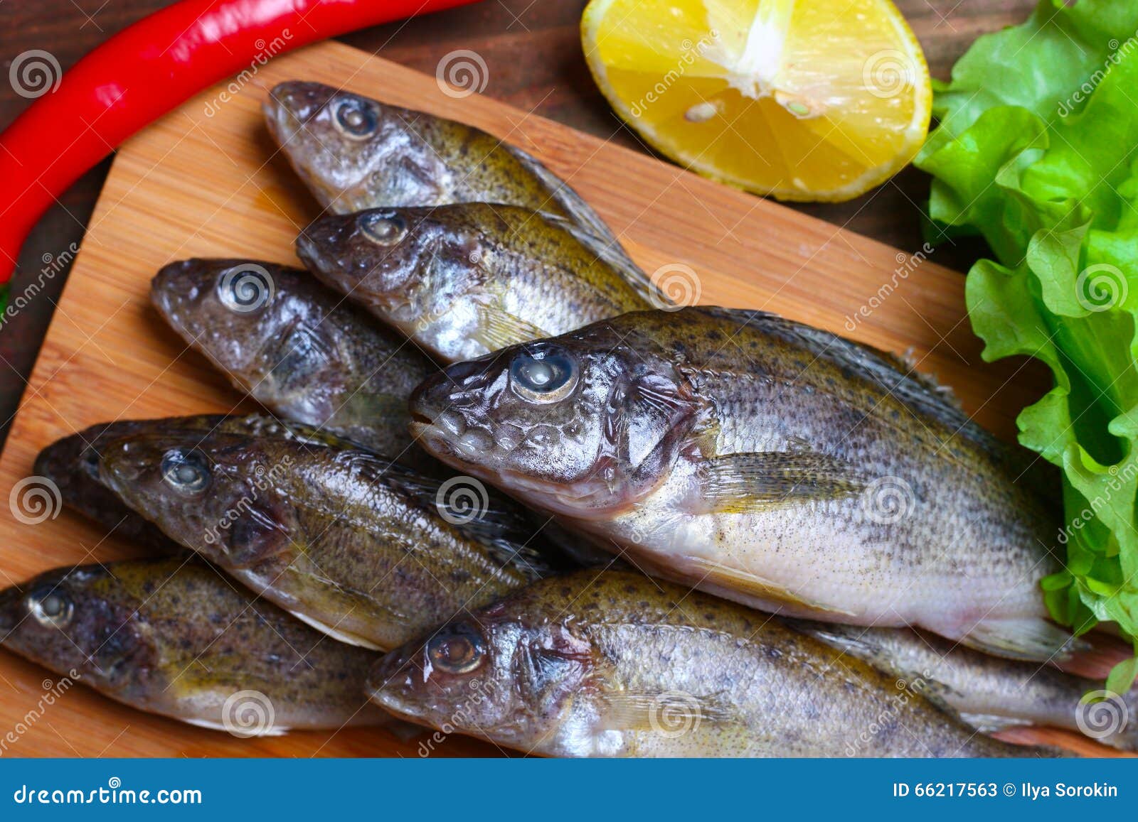 Raw Redfish Ruff Fish on the Kitchen Table with Vegetables and Lemon ...