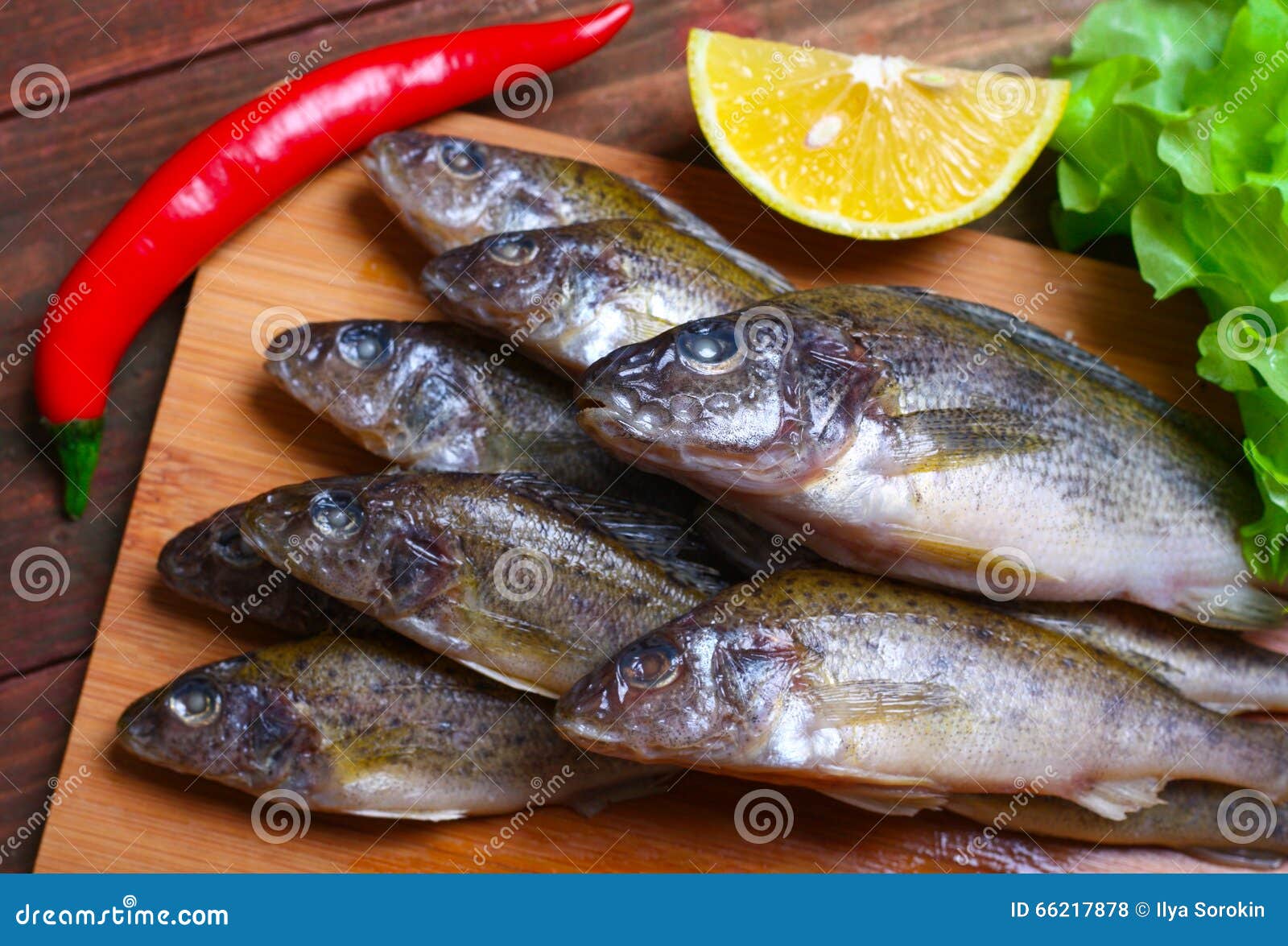 Raw Redfish Ruff Fish on the Kitchen Table with Vegetables and Lemon ...