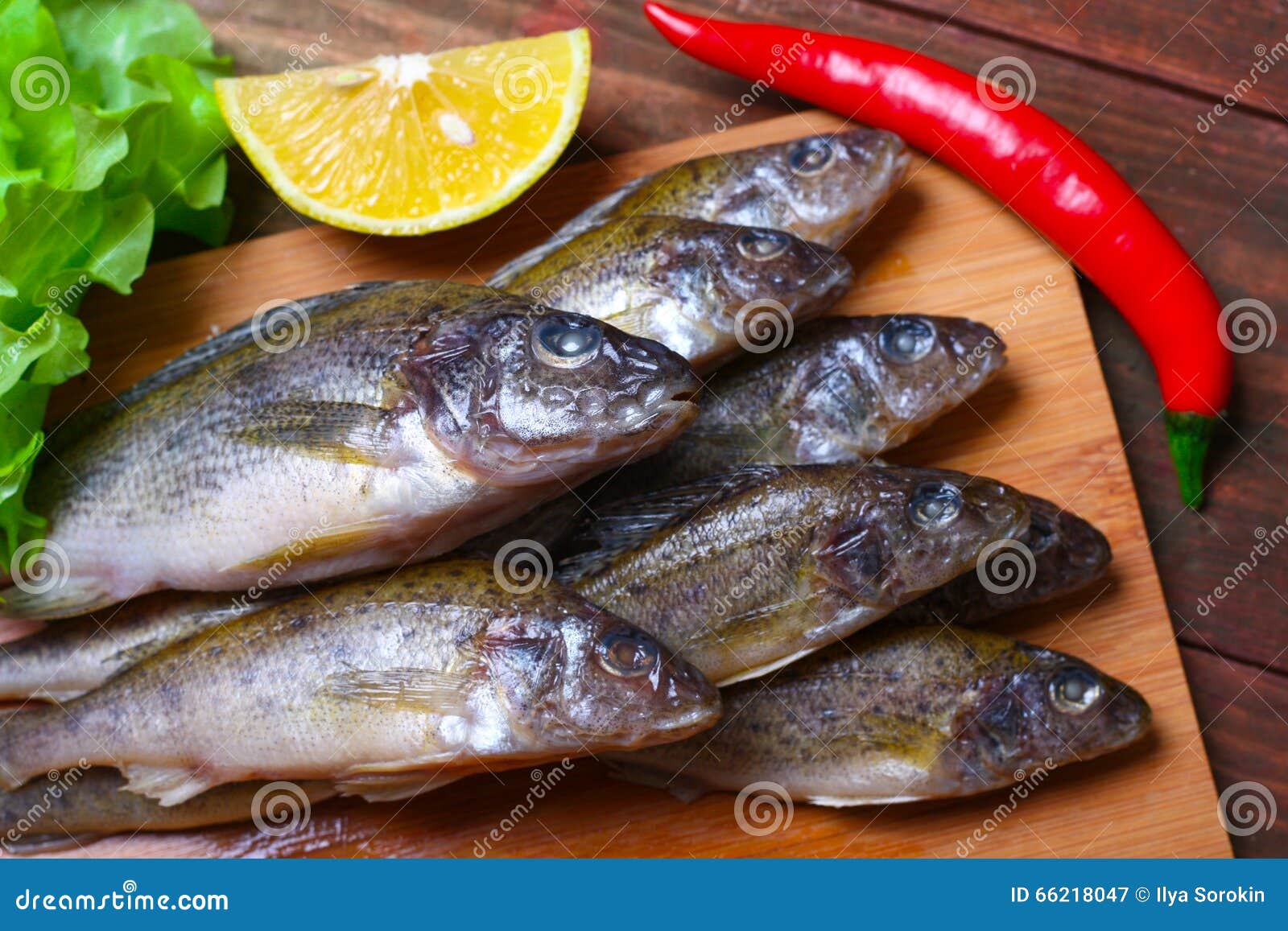 Raw Redfish Ruff Fish on the Kitchen Table with Vegetables and Lemon ...