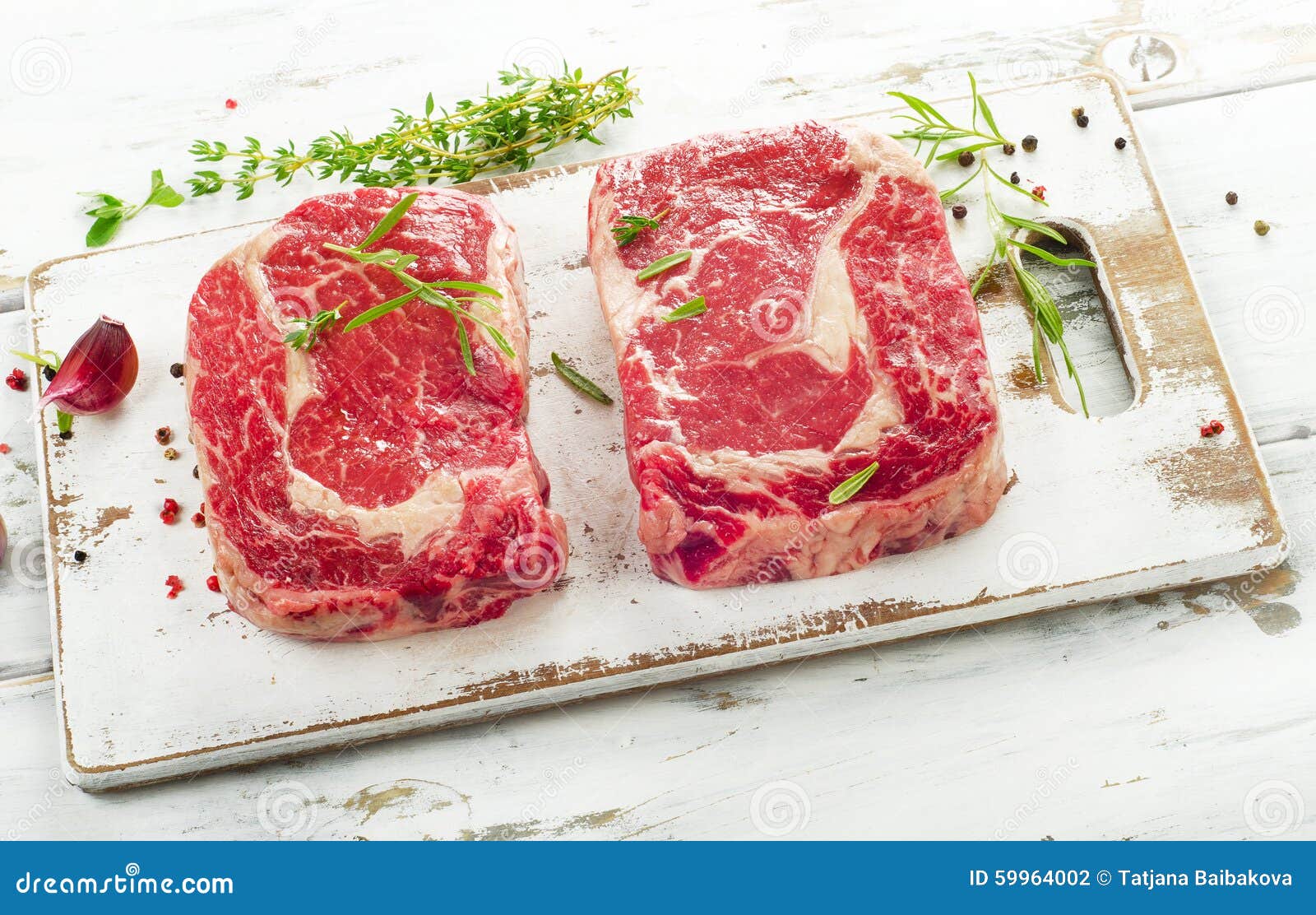 Raw Rib Eye Steaks on a Wooden Cutting Board. Stock Photo - Image of ...