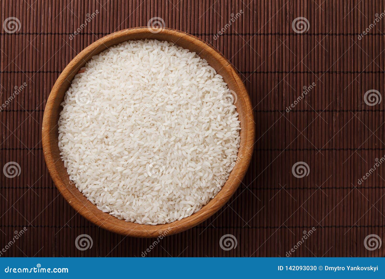 Raw rice in wooden bowl stock photo. Image of white - 142093030
