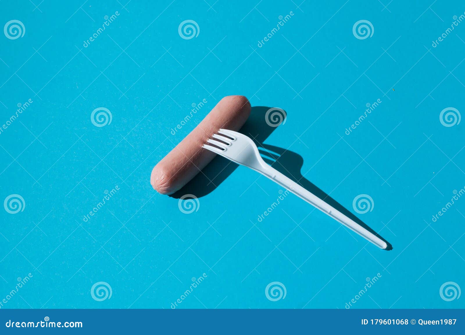 Raw Sausage on a Blue Background with a Plastic Fork Stock Photo ...