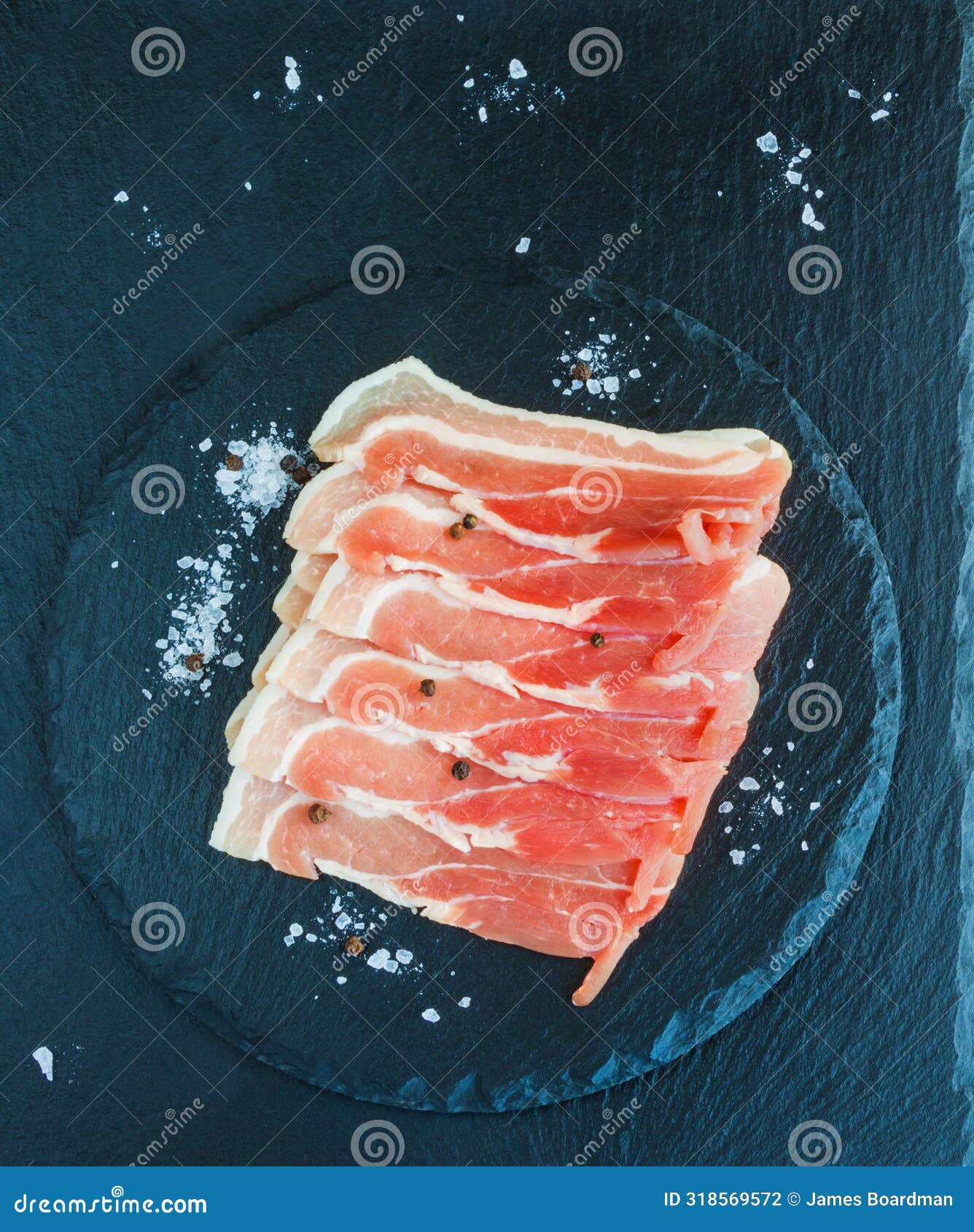 Raw Sliced Bacon on Black Stone Background. Top View Stock Photo ...