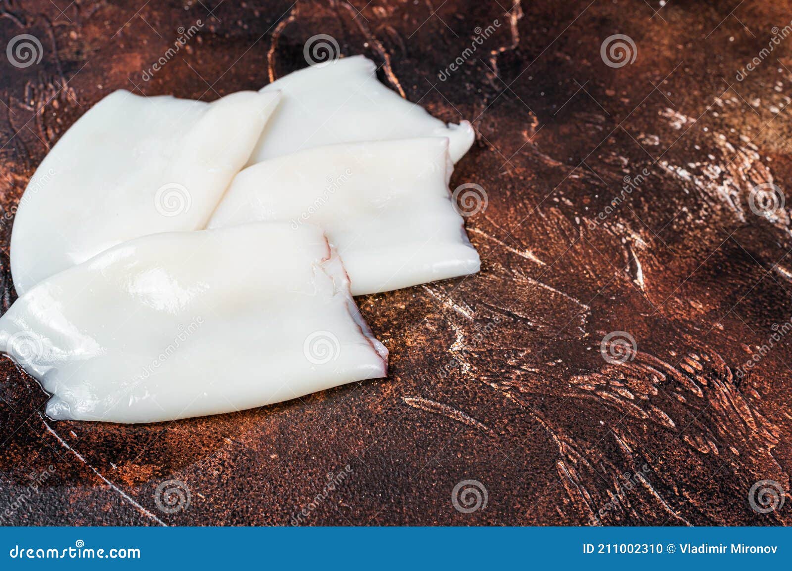 Raw Squid or Calamari Tubes on a Kitchen Table. Dark Background. Top ...