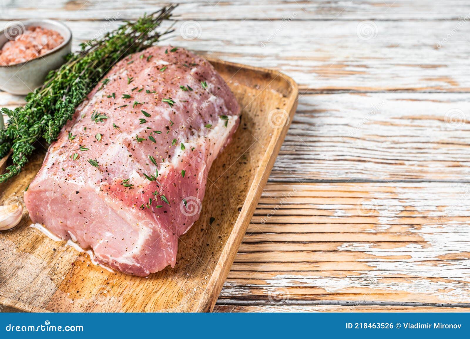 Raw Whole Boneless Pork Loin Meat With Thyme And Salt On Rustic Board White Wooden Background
