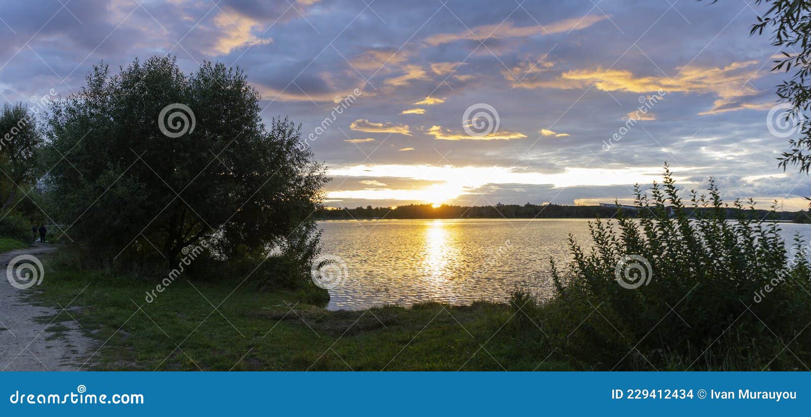 The Rays of the Dawn Sun on the Lake. Reflection of Sunset Clouds in ...